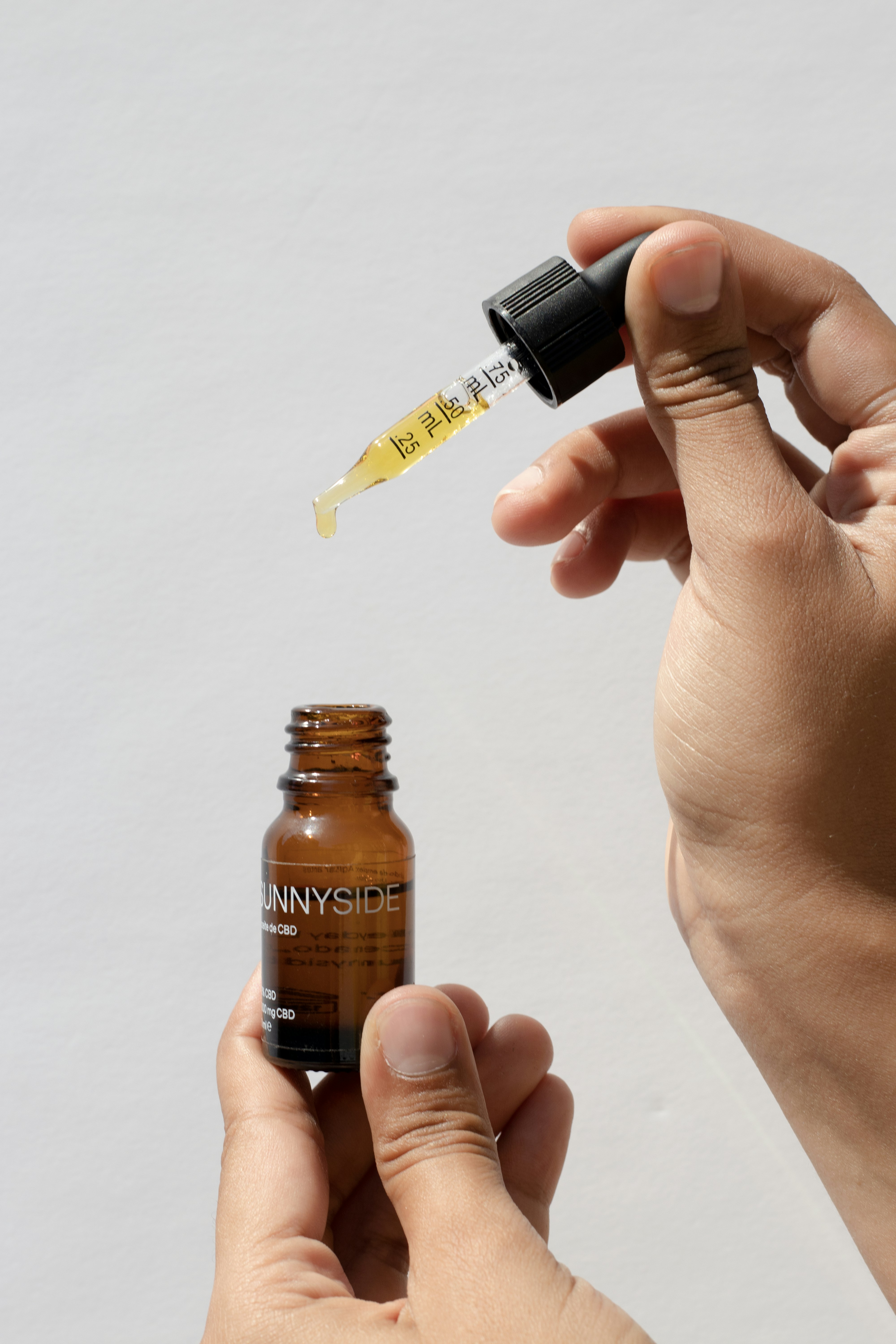 A person is holding a small bottle with a dropper photo – Free Cbd ...