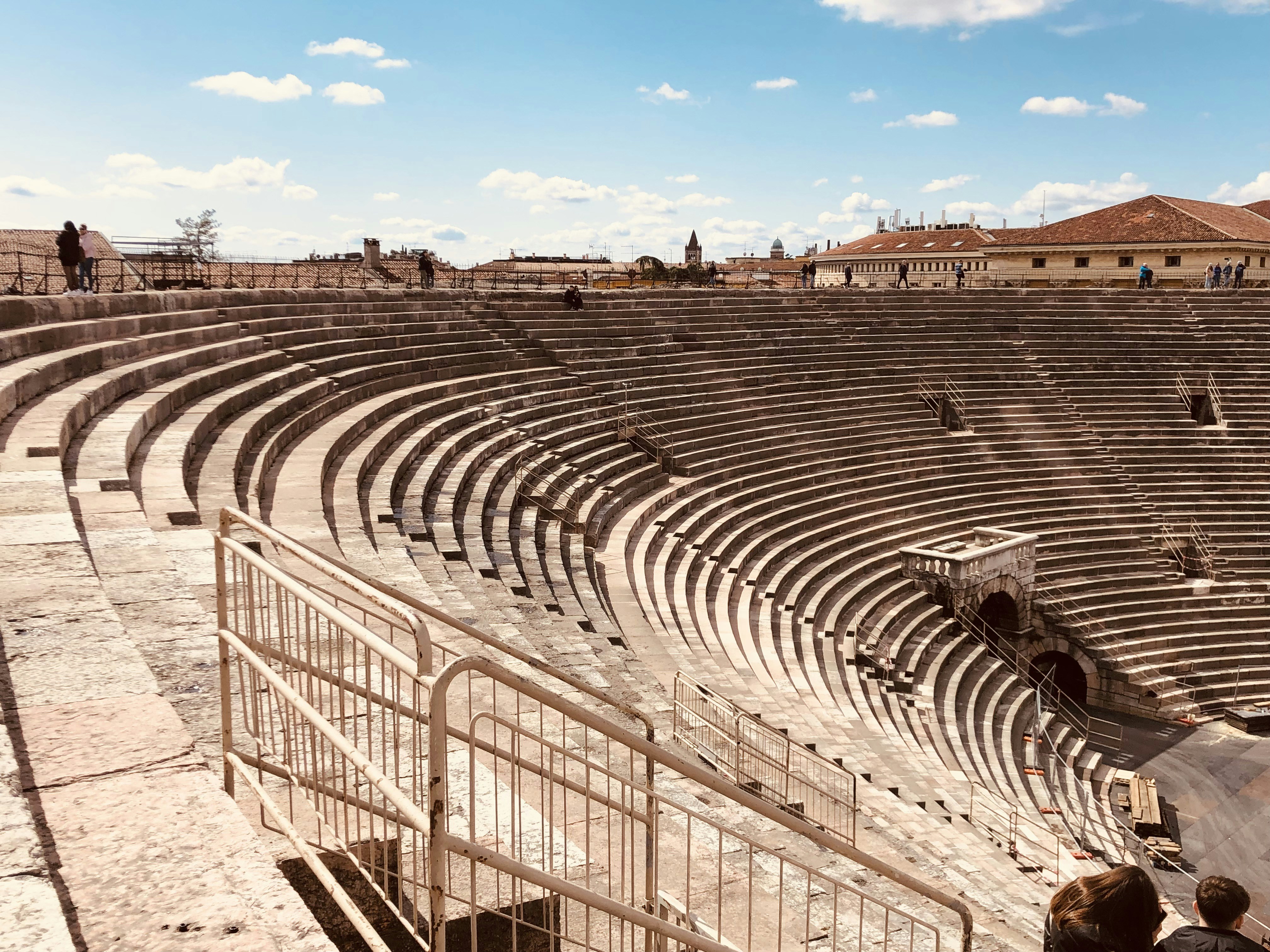 Curved stone seating of an ancient amphitheater, showcasing the architectural grandeur and historical significance of the venue.