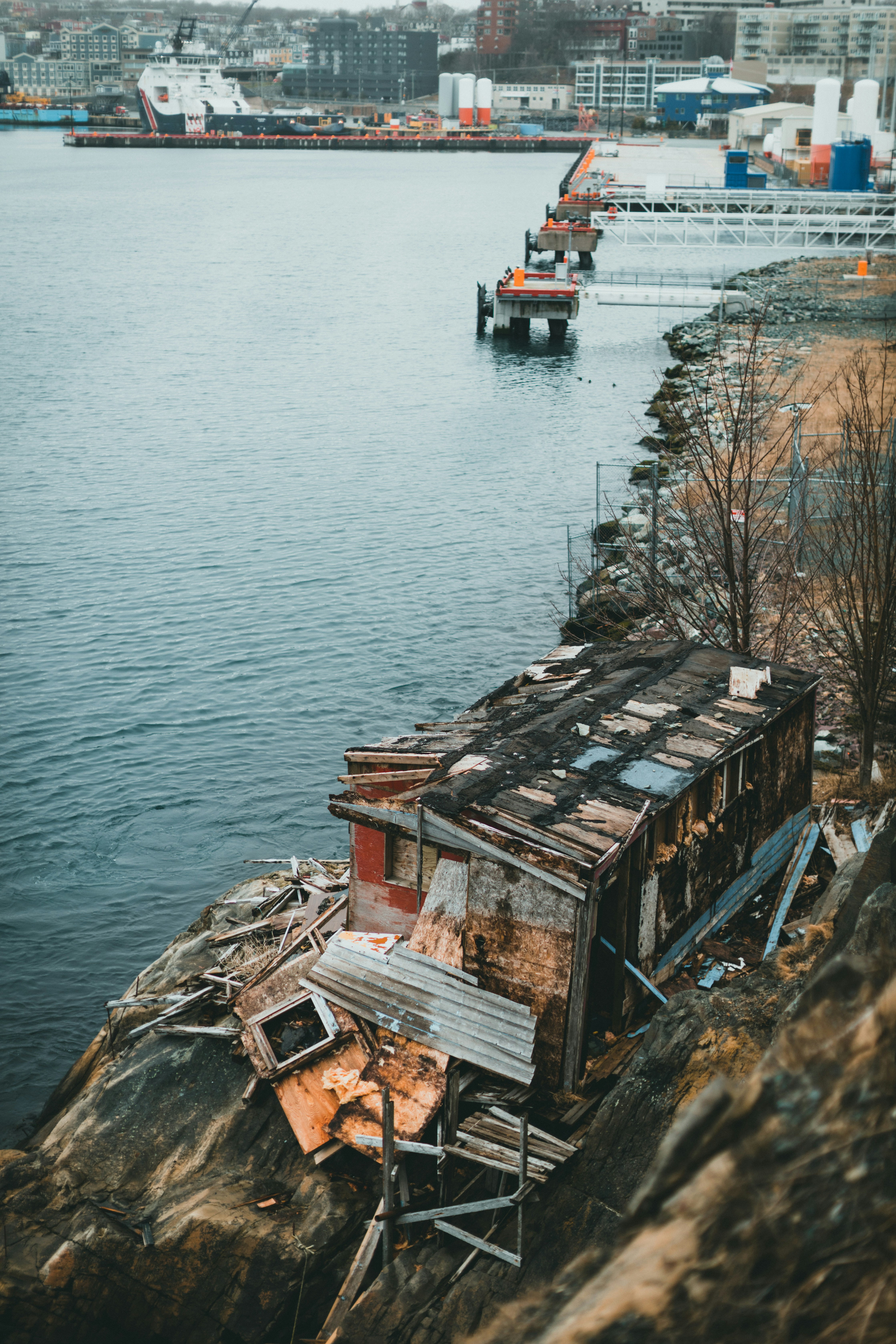 a small shack sitting on top of a cliff next to a body of water