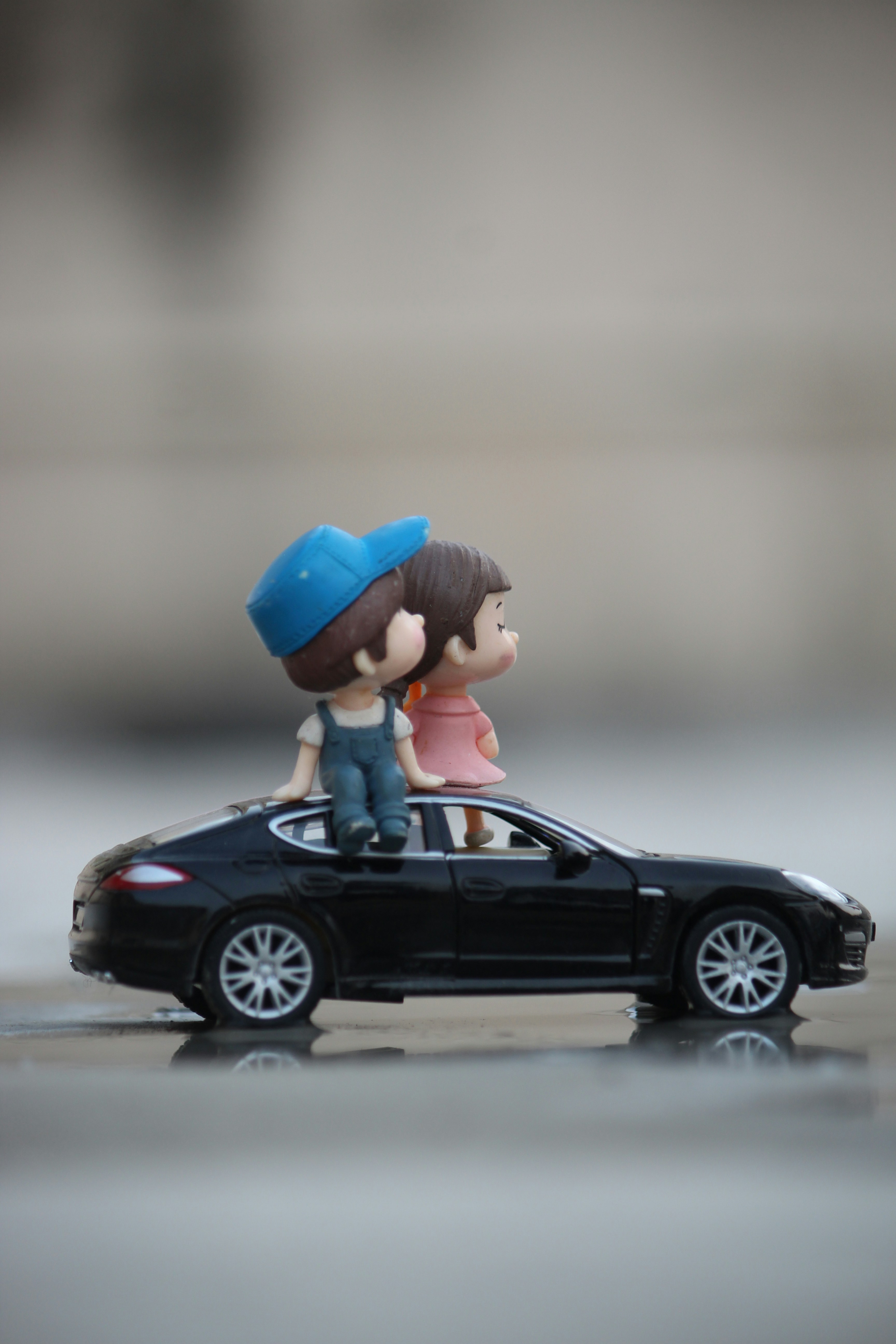 Tiny Duo on a Black Convertible: A Whimsical Miniature Drive