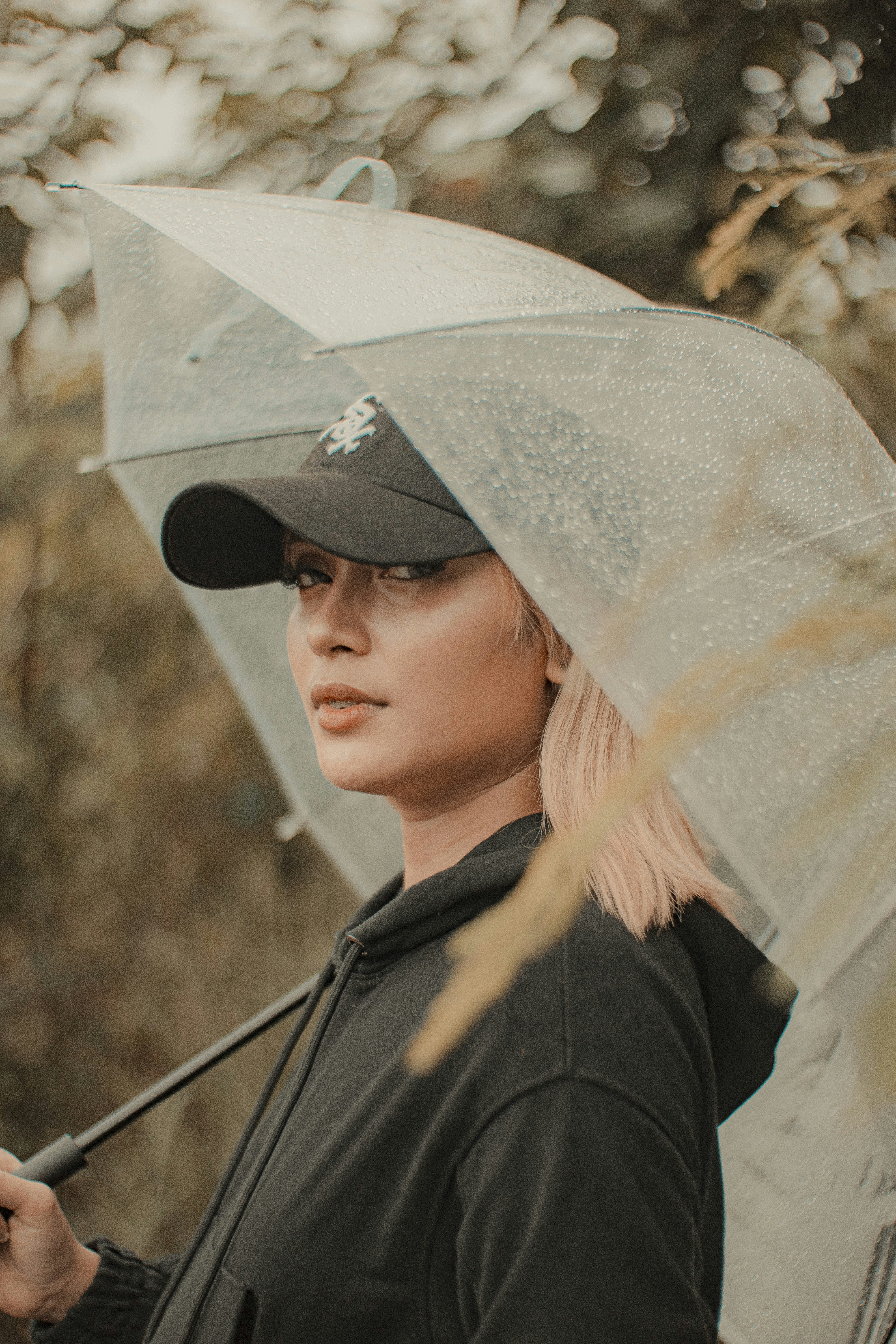 Portrait under translucent umbrella: a calm gaze in rain-kissed light
