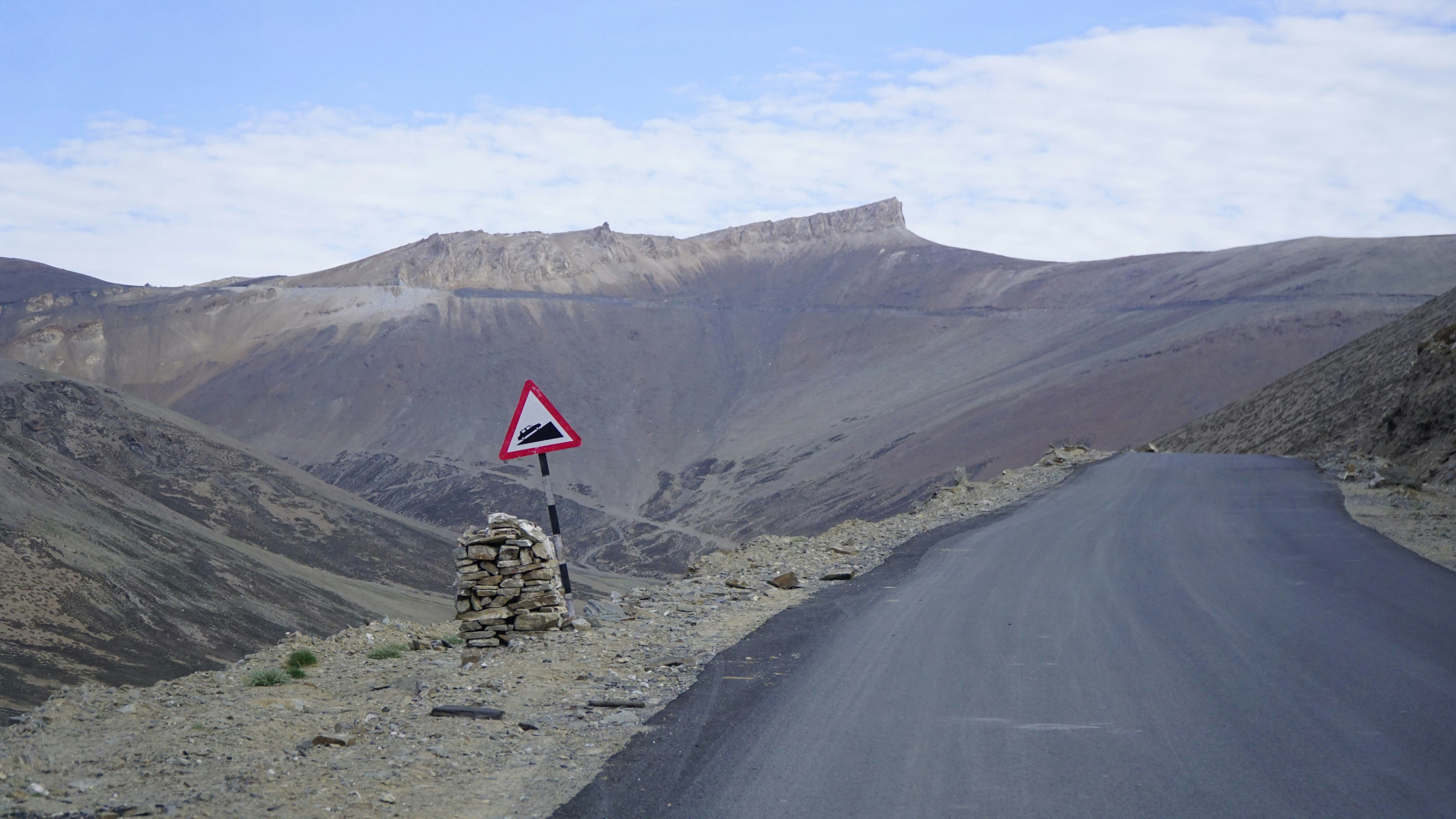 Deserted Highway Wave: A winding ascent under a cliff-slate sky