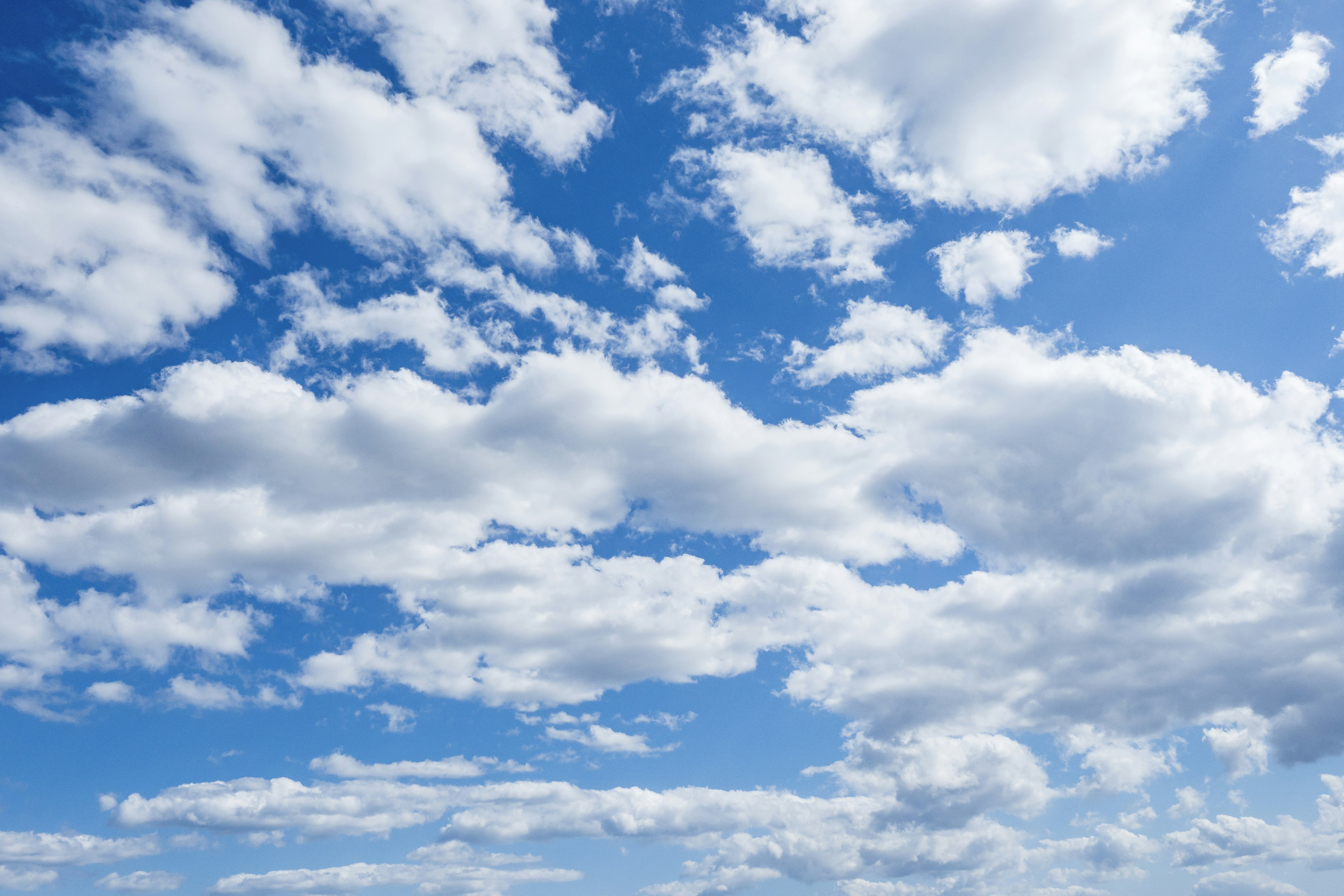 Sky over Peguera, Mallorca, Isla Baleares, Spain | a group of people standing on top of a beach under a cloudy blue sky