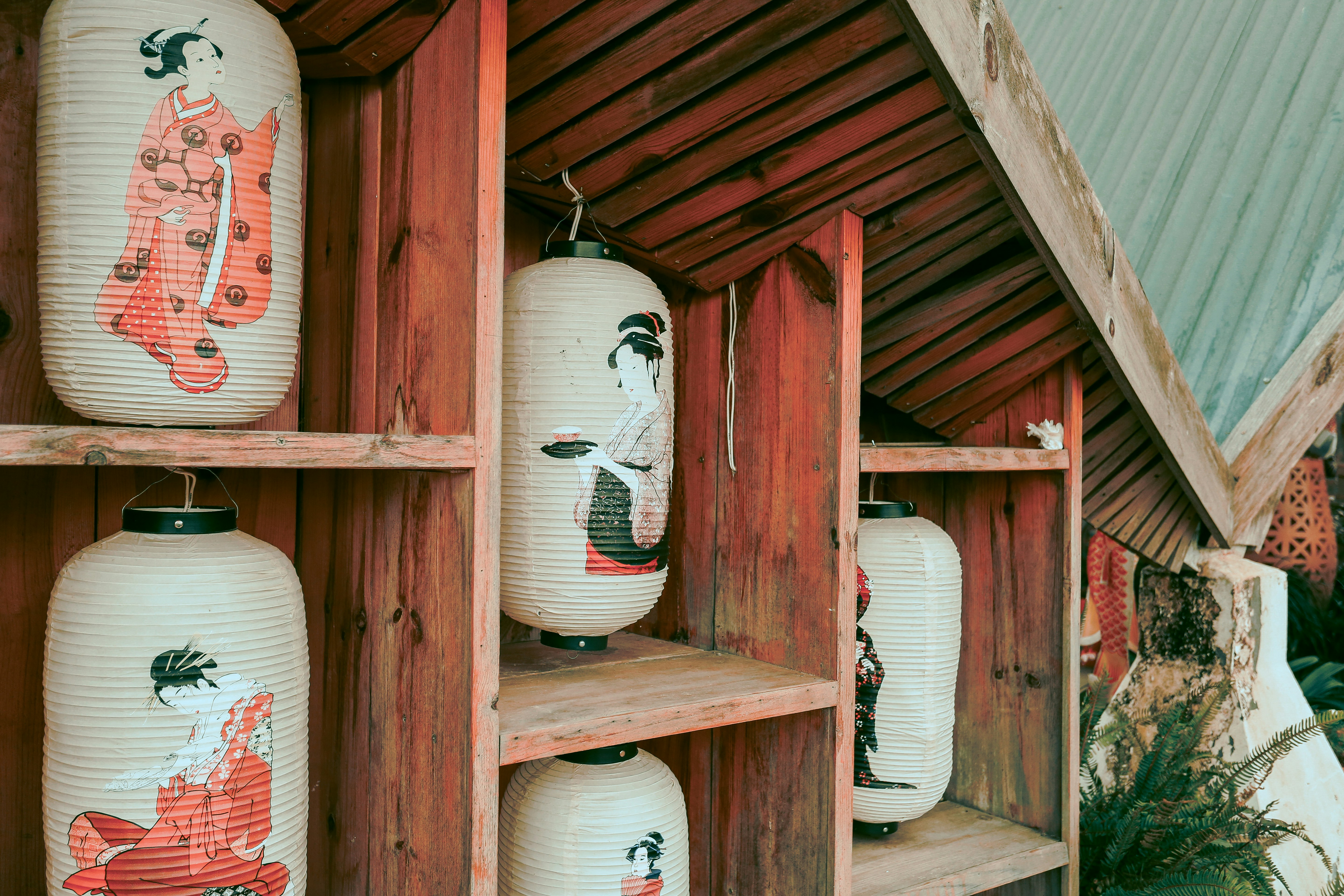 Lanterns in a Weathered Nook: Warm Glow on Red-Printed Paper