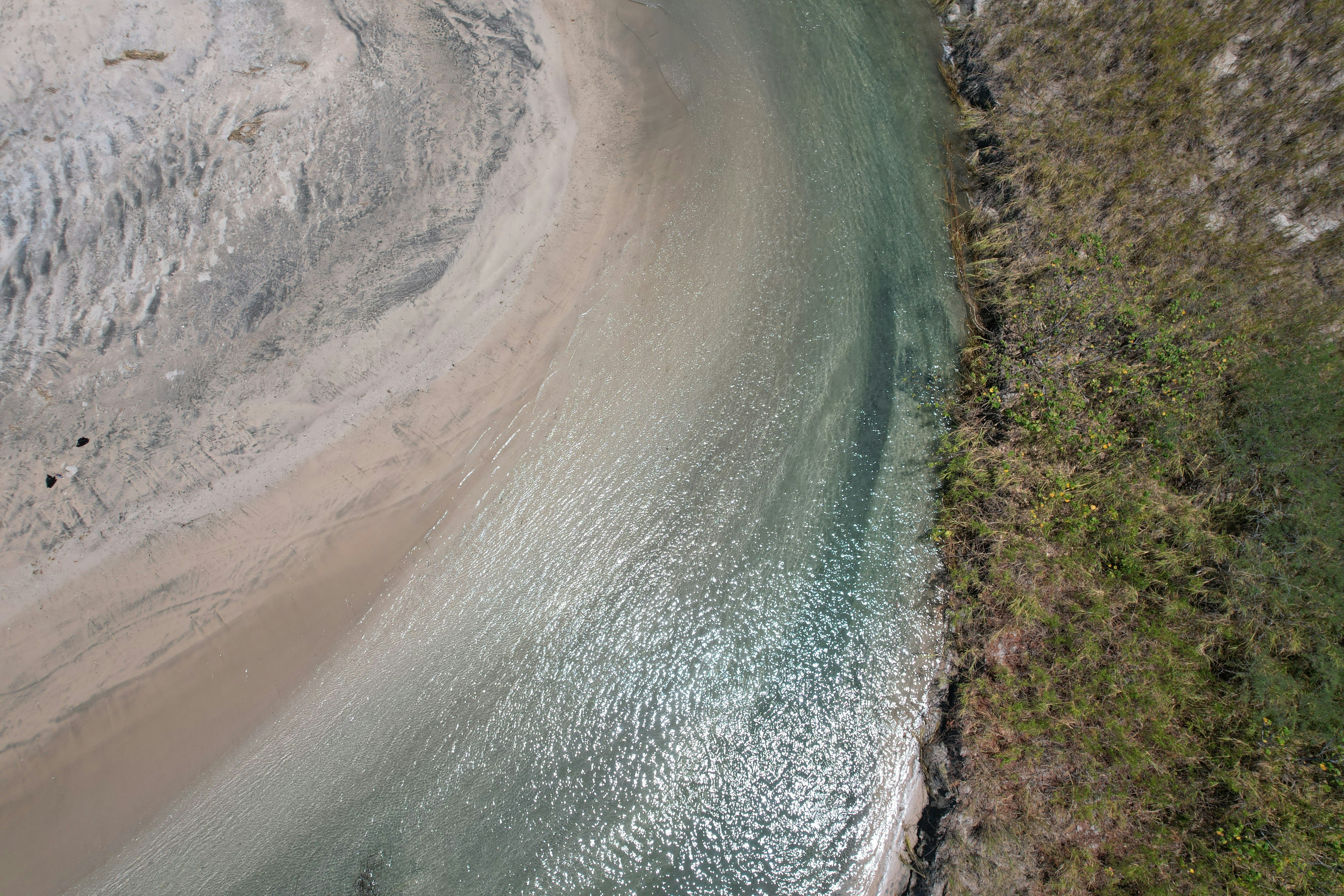 Curving riverbank with sandy shores and lush vegetation, showcasing the harmony between land and water.