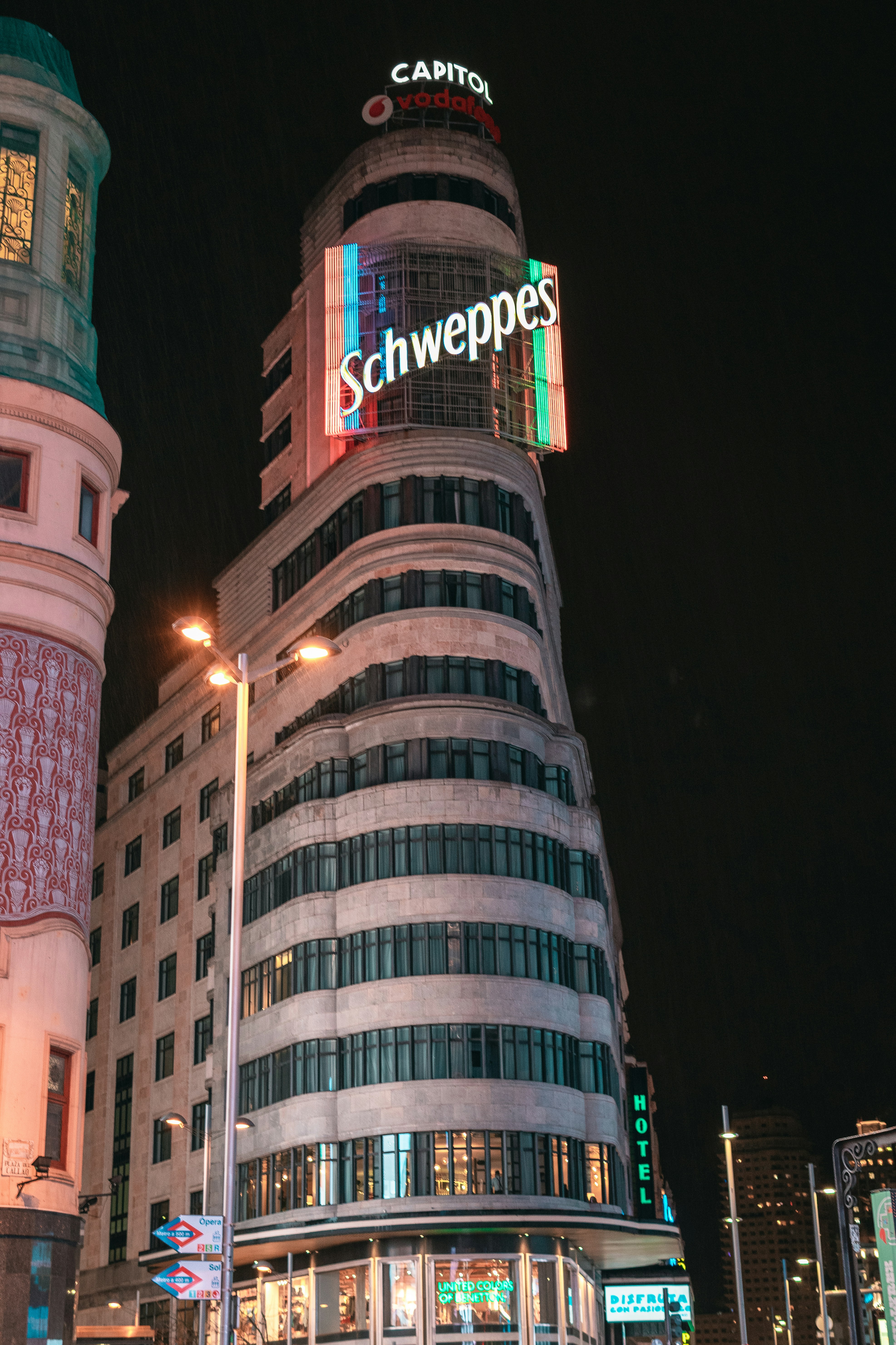 Schweppes Neon Crown Over a Spiral-Fronted Night Tower