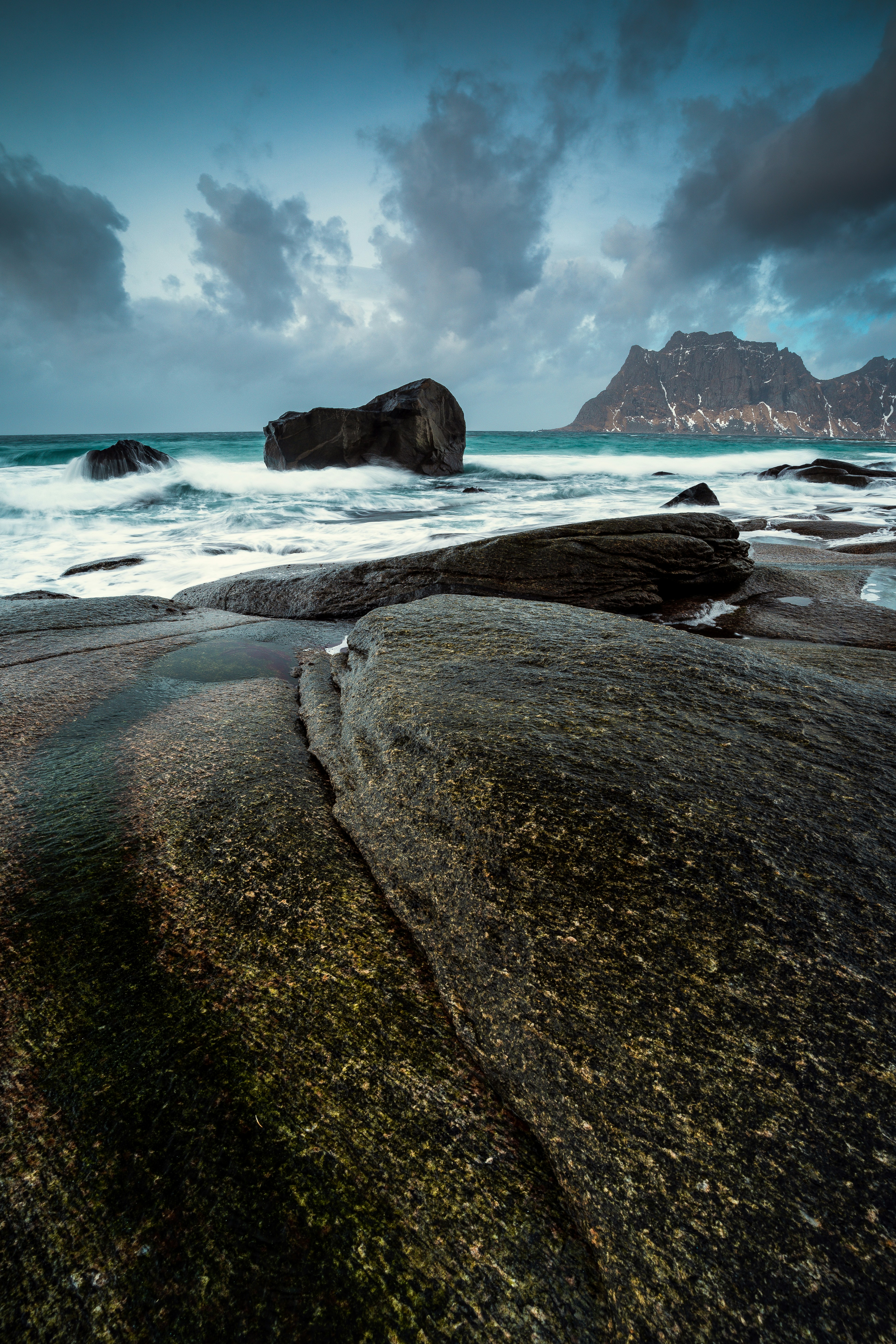 Un gros rocher assis au sommet d’une plage au bord de l’océan photo ...