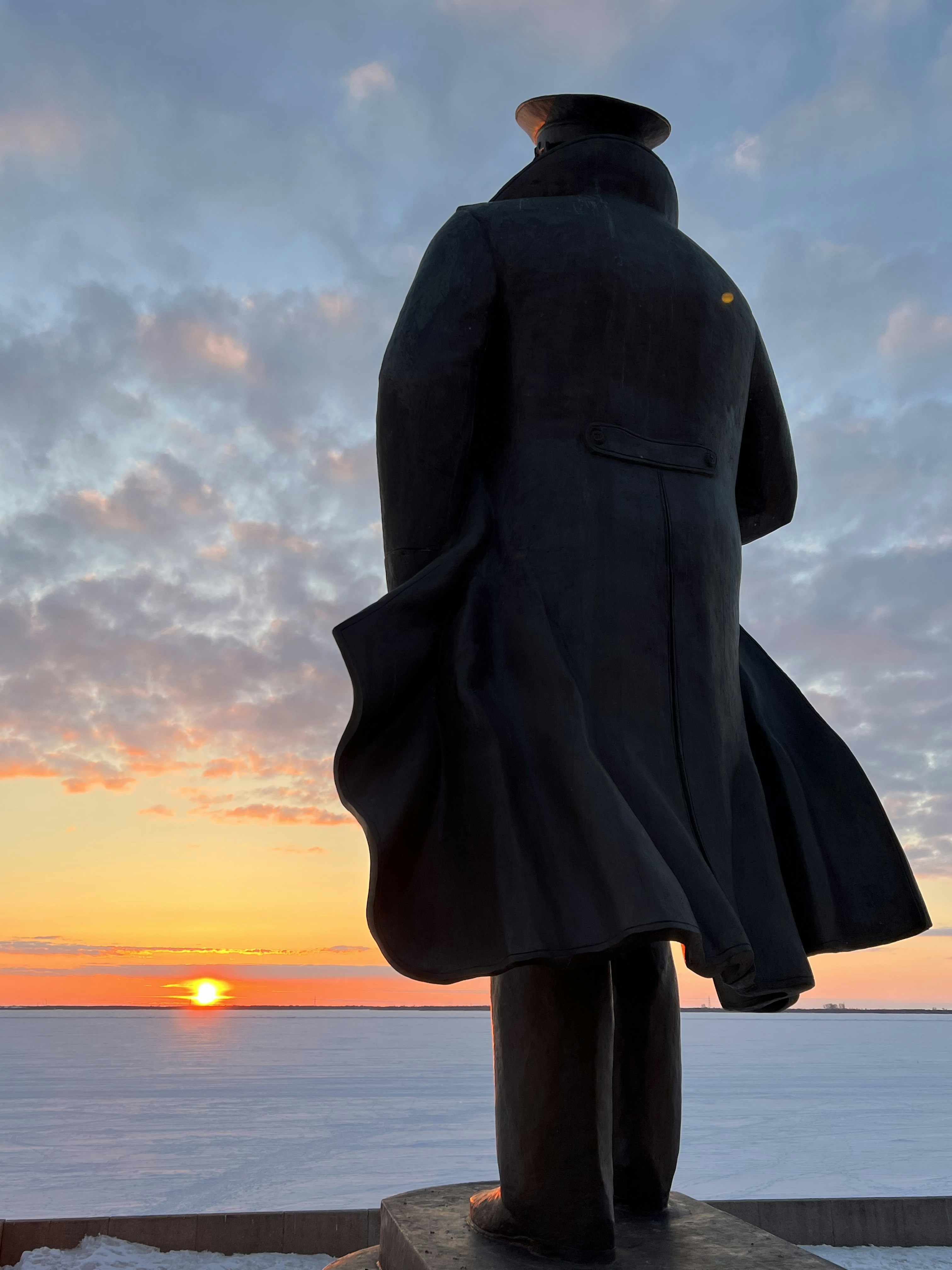 Cloaked Sentinel at Sunset Over a Quiet Frozen Horizon