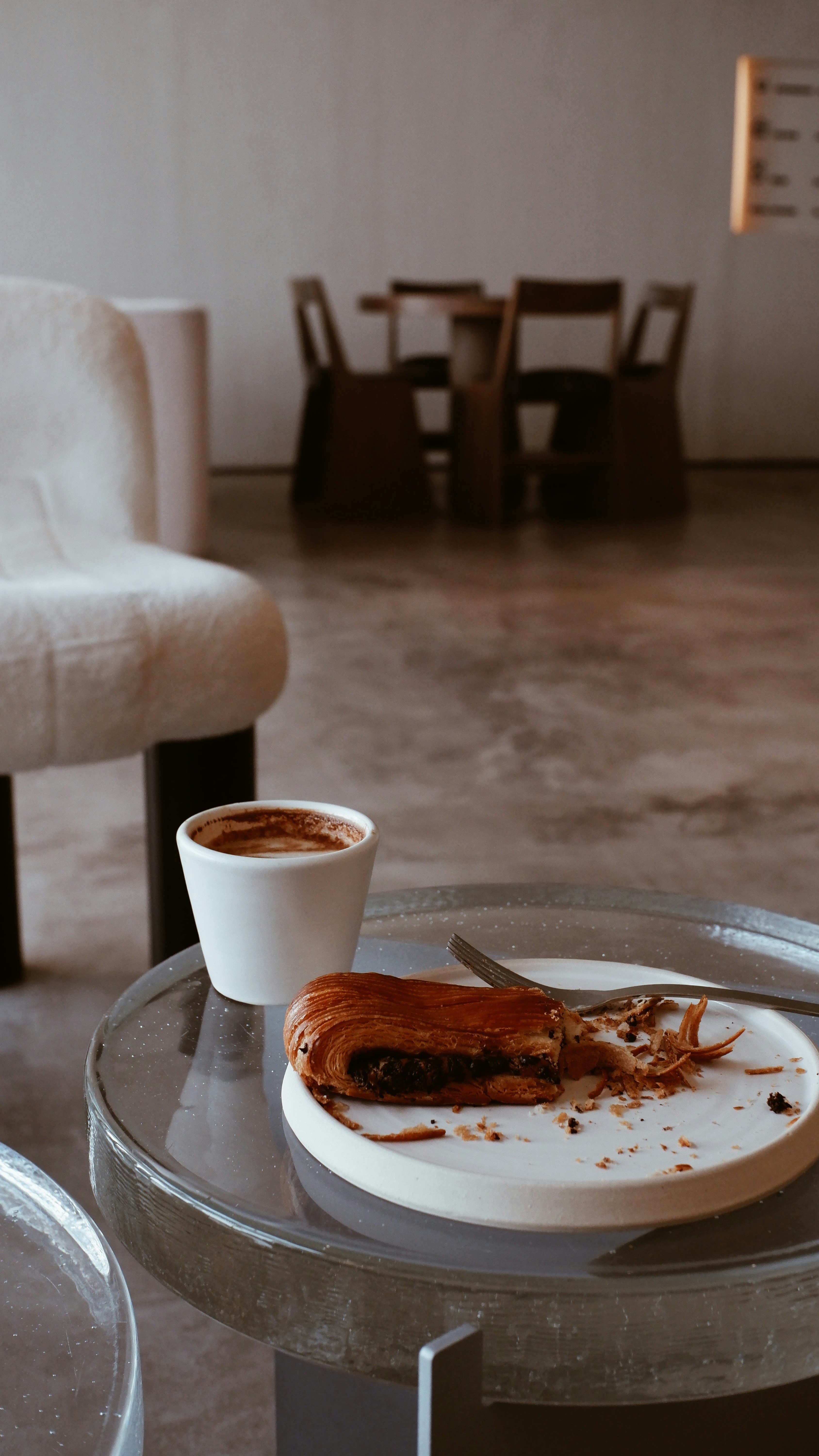 Crumbs and Quiet Light: A Pastry Moment on a Glass Table