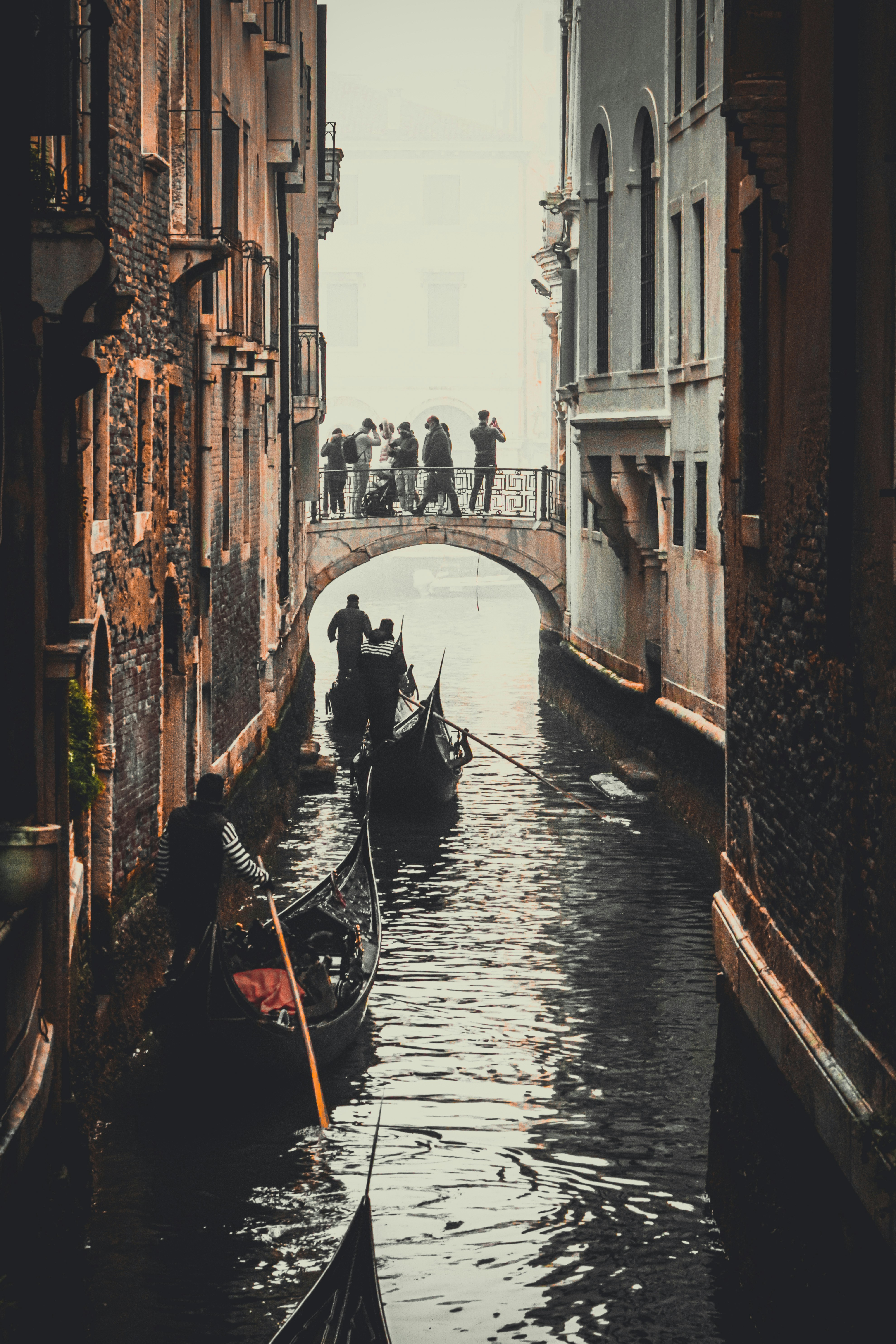 Gondola Ballet Under a Weathered Venetian Bridge