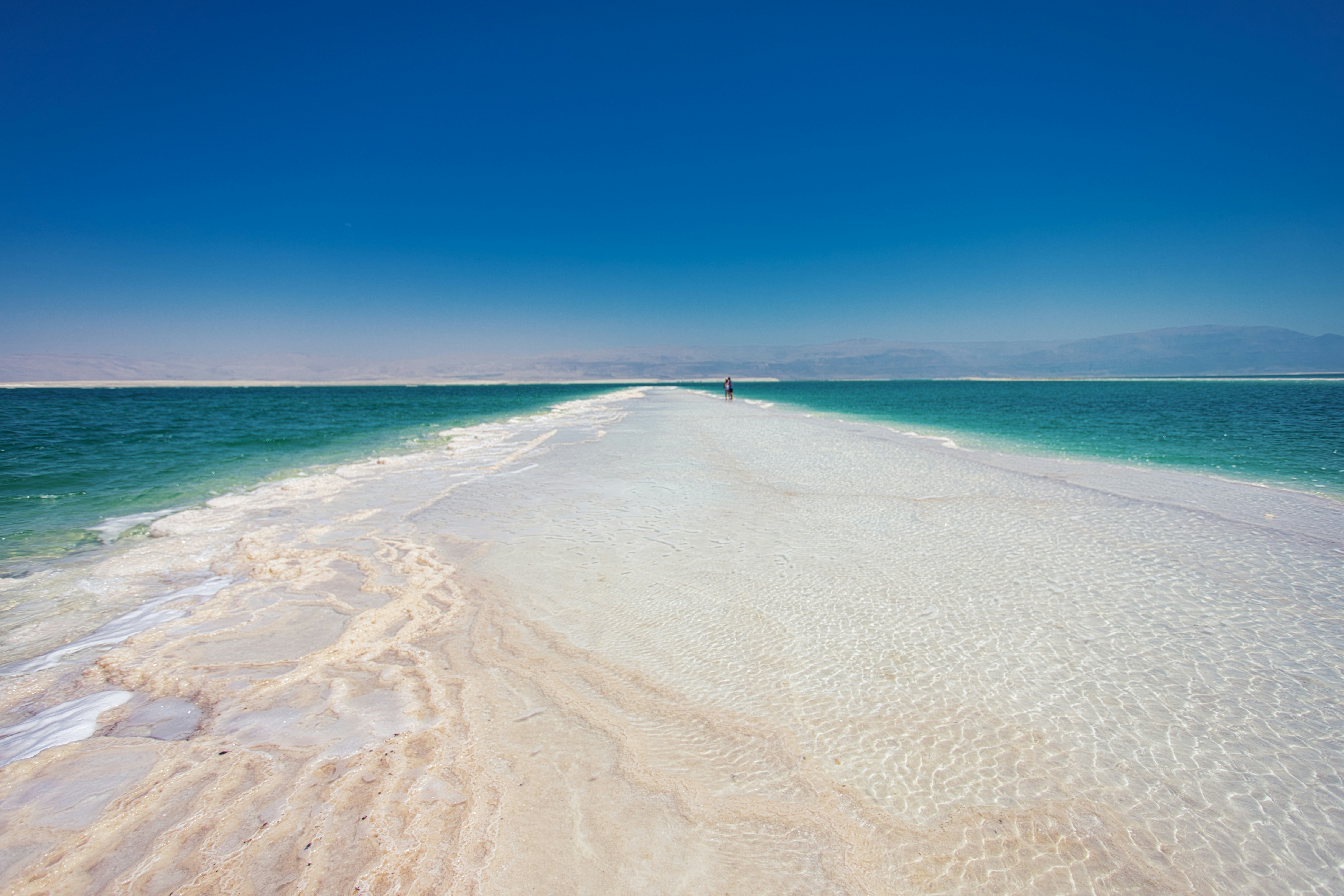 A long stretch of white sand stretches out into the ocean photo – Free ...