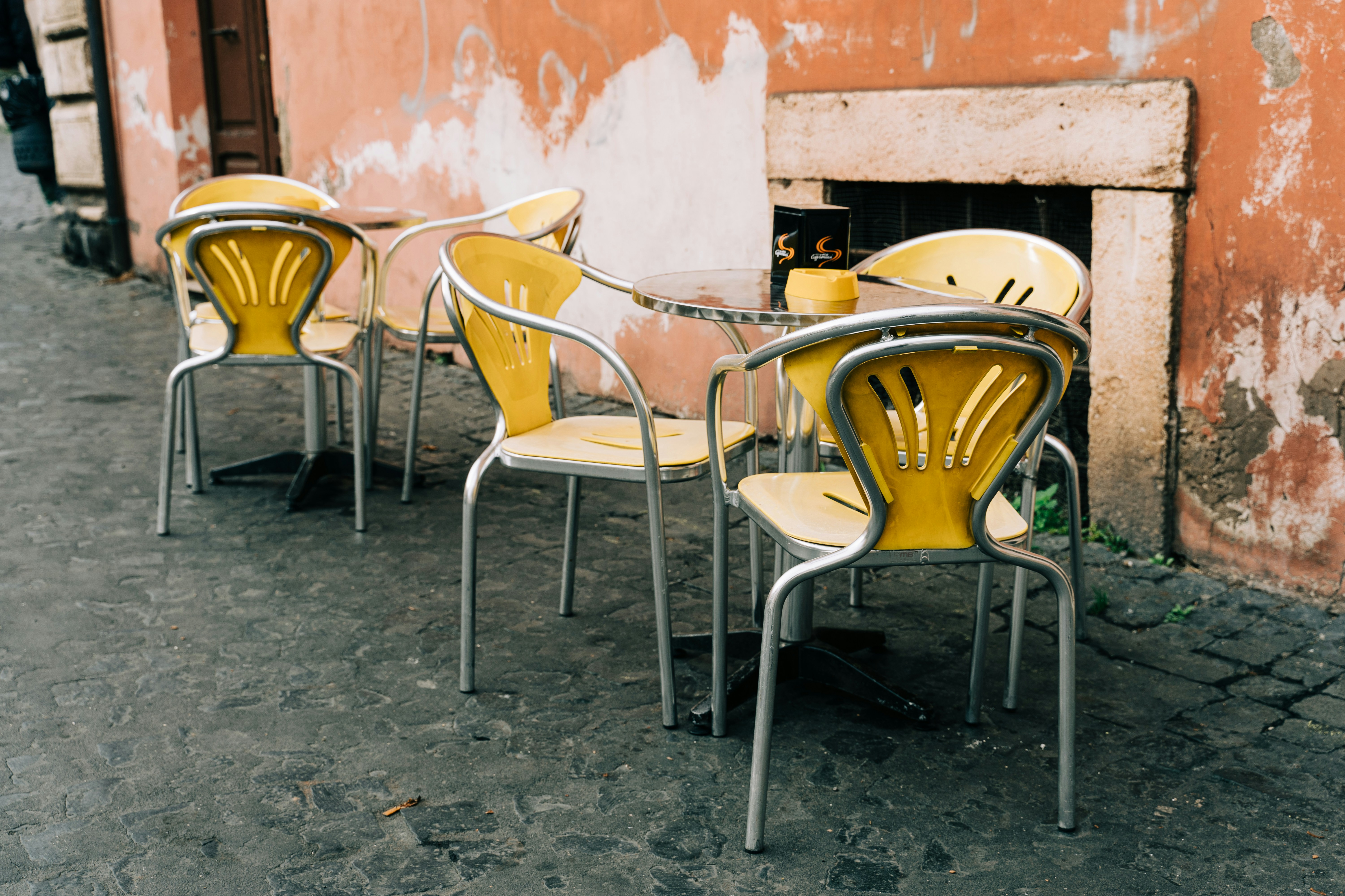 Courtyard Chairs: Sunlit Yellow Seats by a Weathered Orange Wall