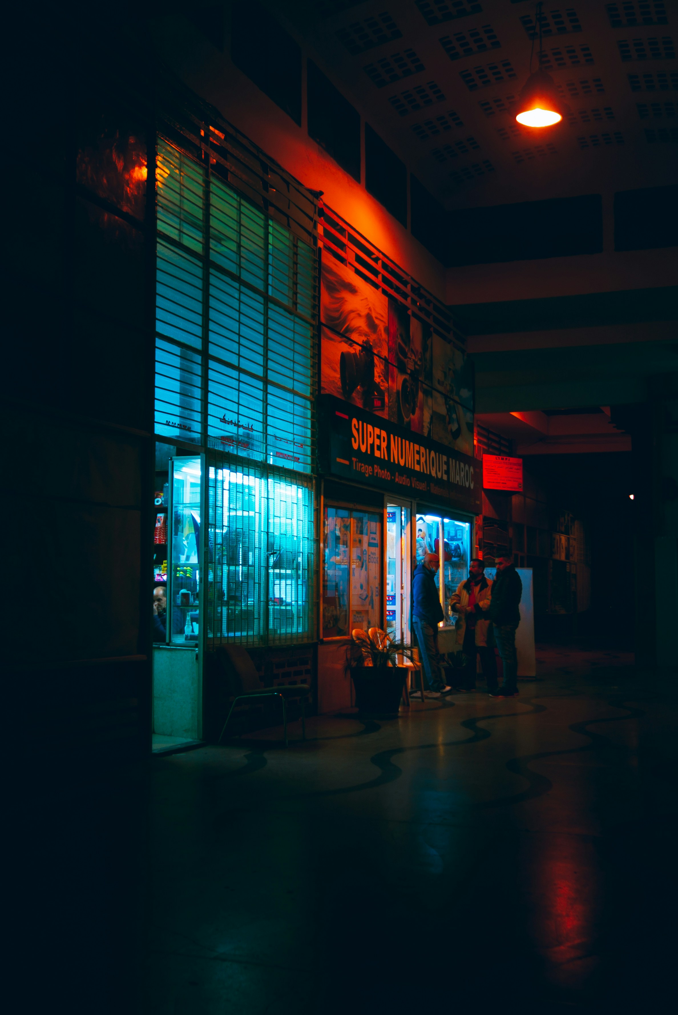 A group of people standing outside of a store at night photo – Free ...