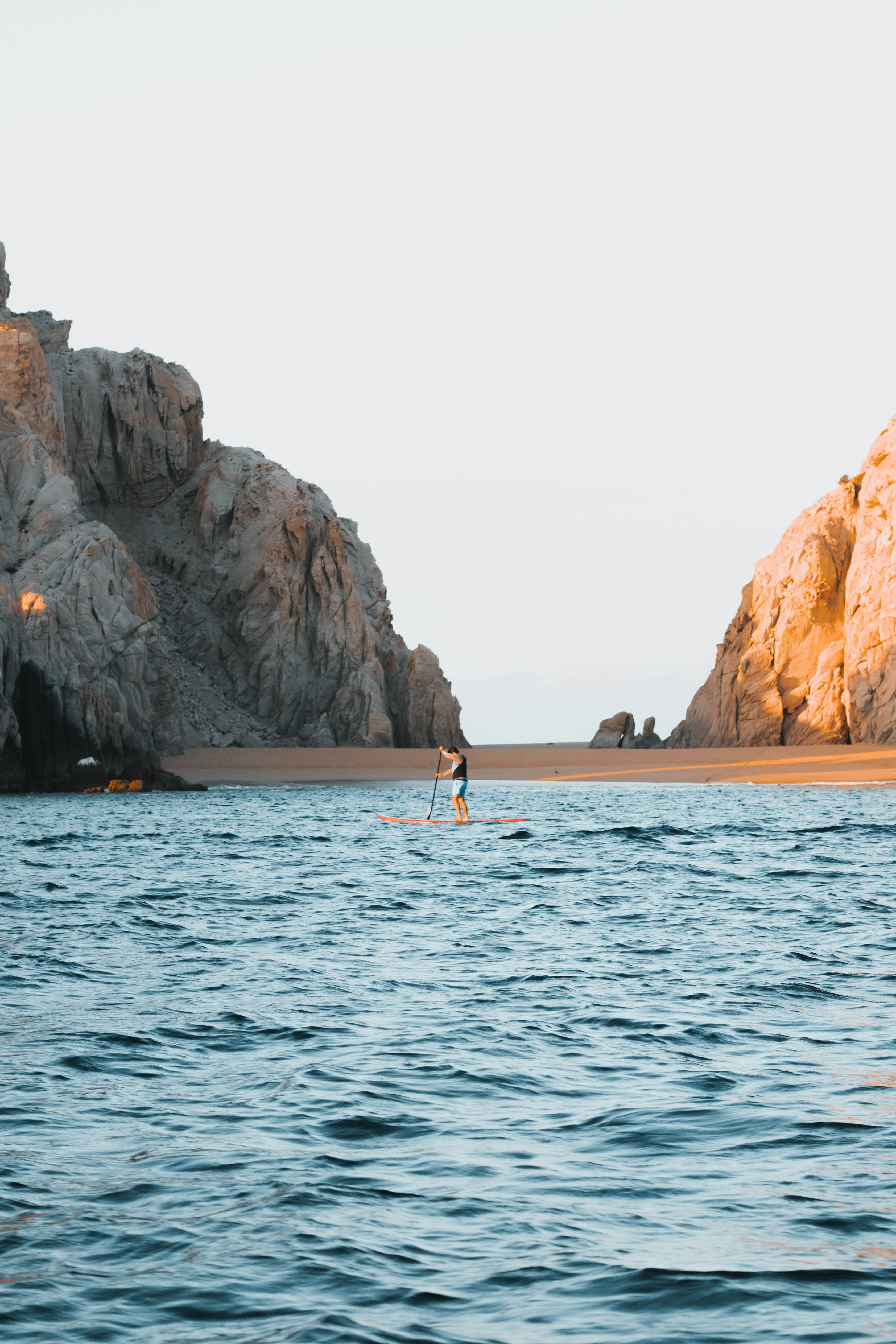 A person riding a surf board on a body of water photo – Free Nature ...