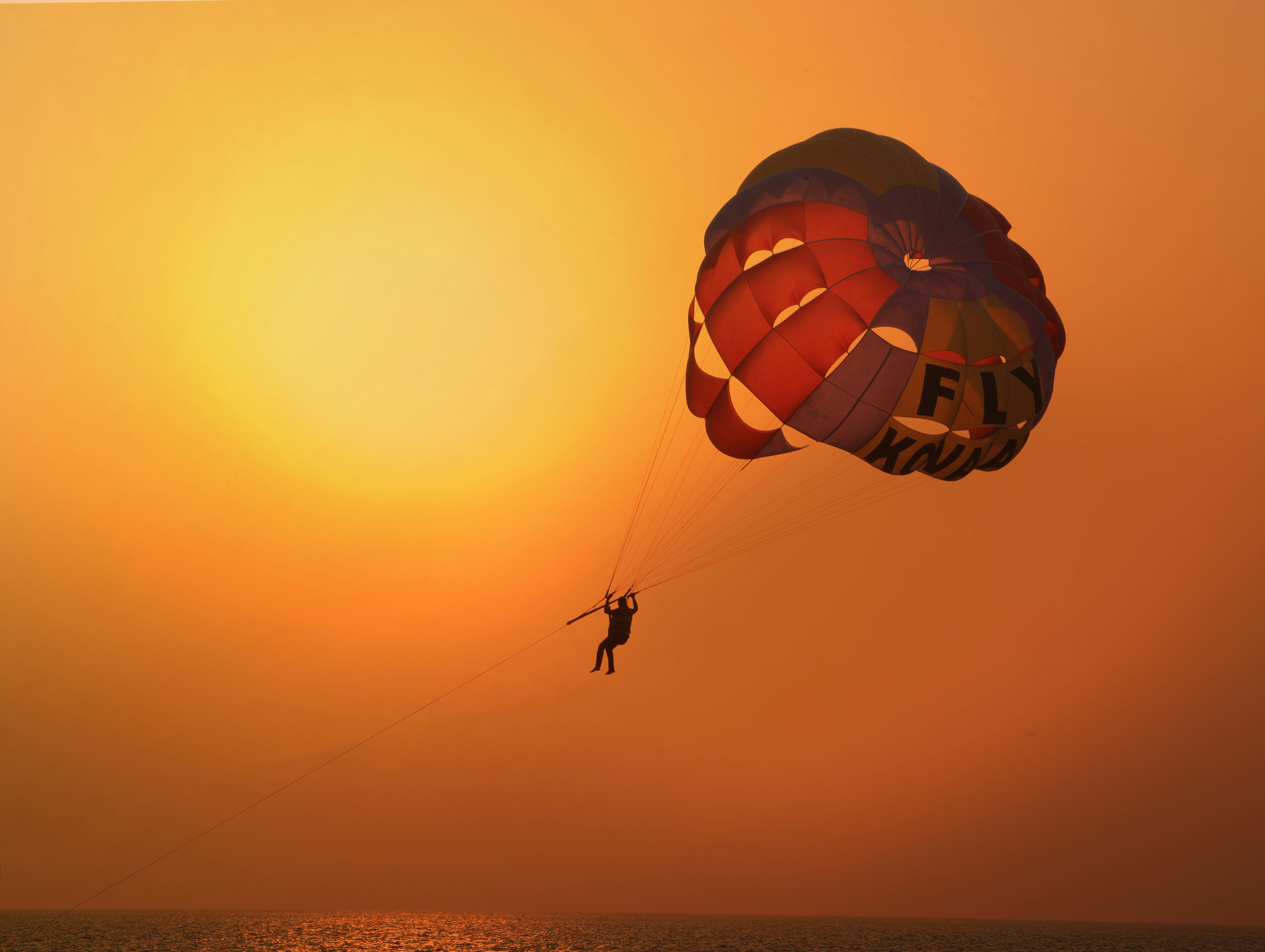 A man flying in parachute at kovalam thiruvananthapuram