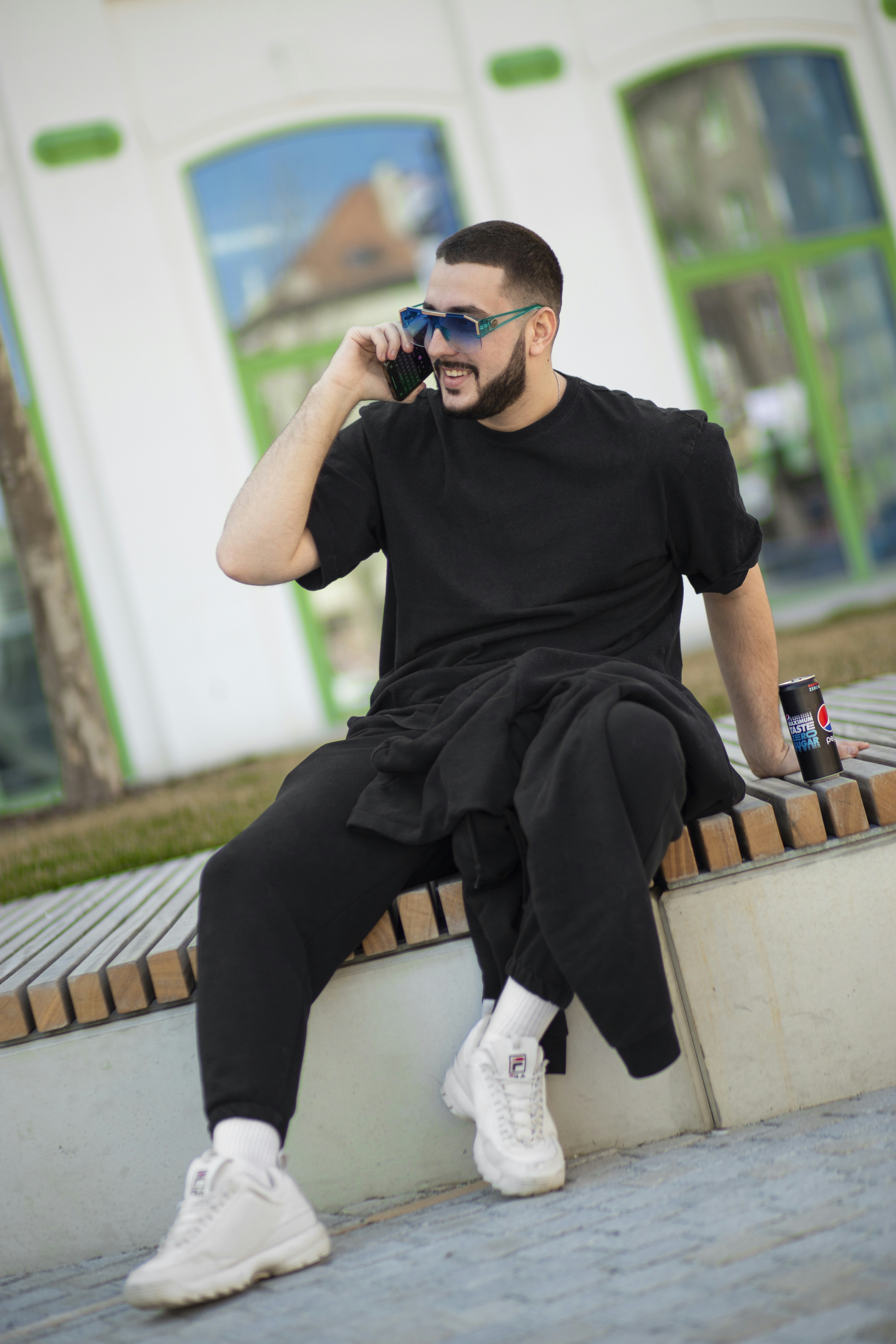 Un homme assis sur un banc parlant au téléphone portable photo – Photo ...
