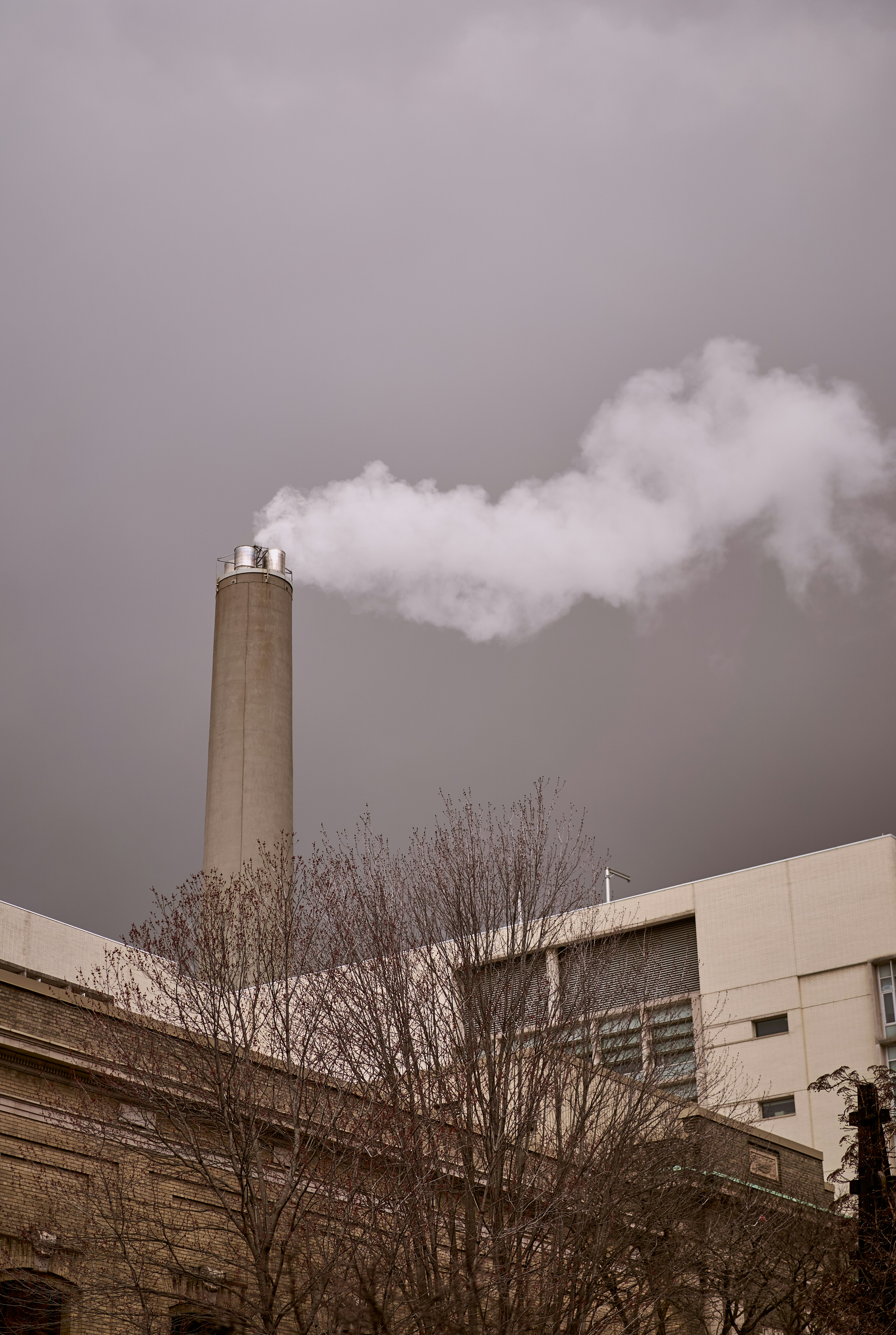 A smokestack emits from the top of a building photo – Free Canada Image ...