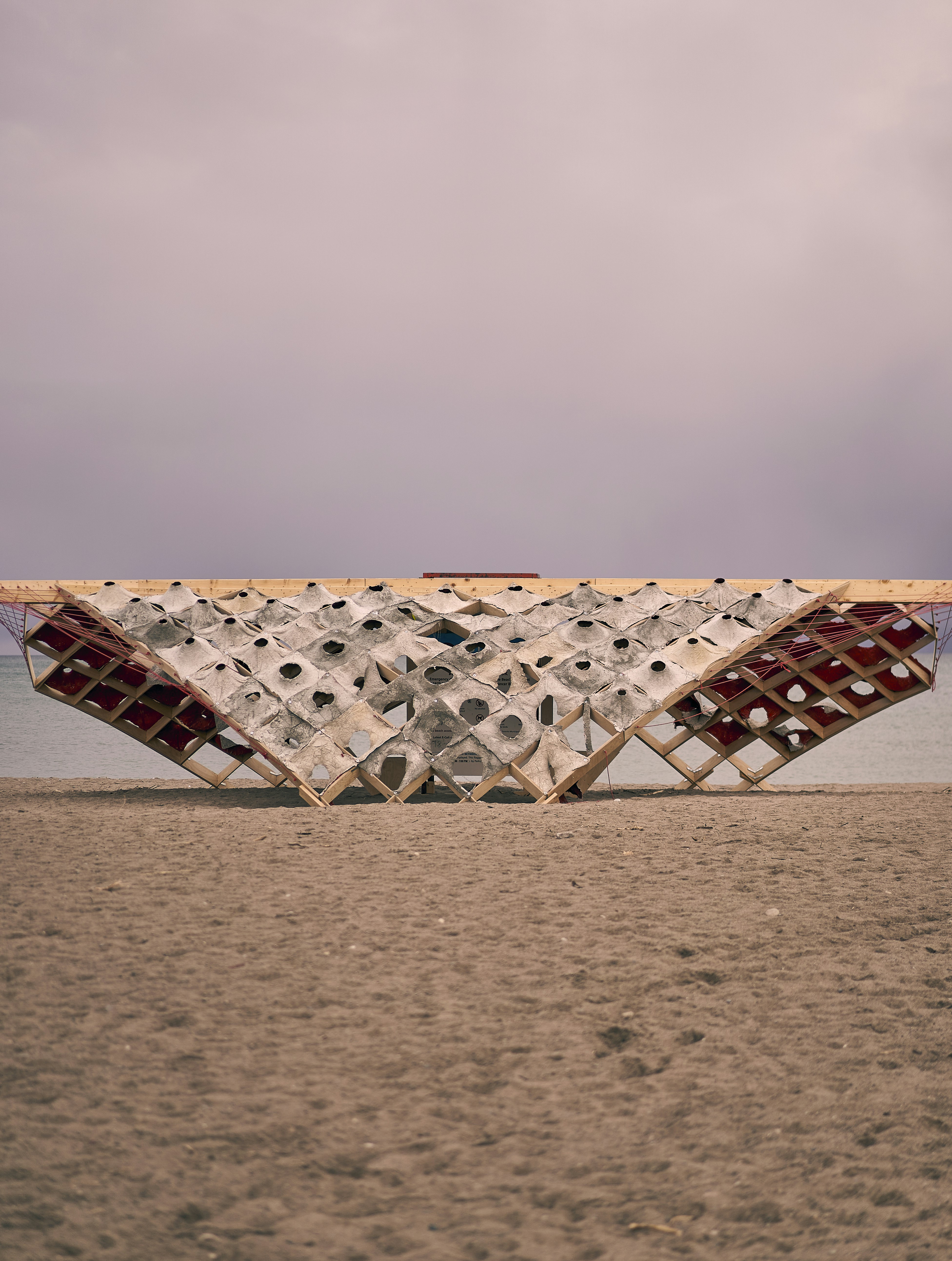 Une grande structure métallique posée au sommet d’une plage de sable ...