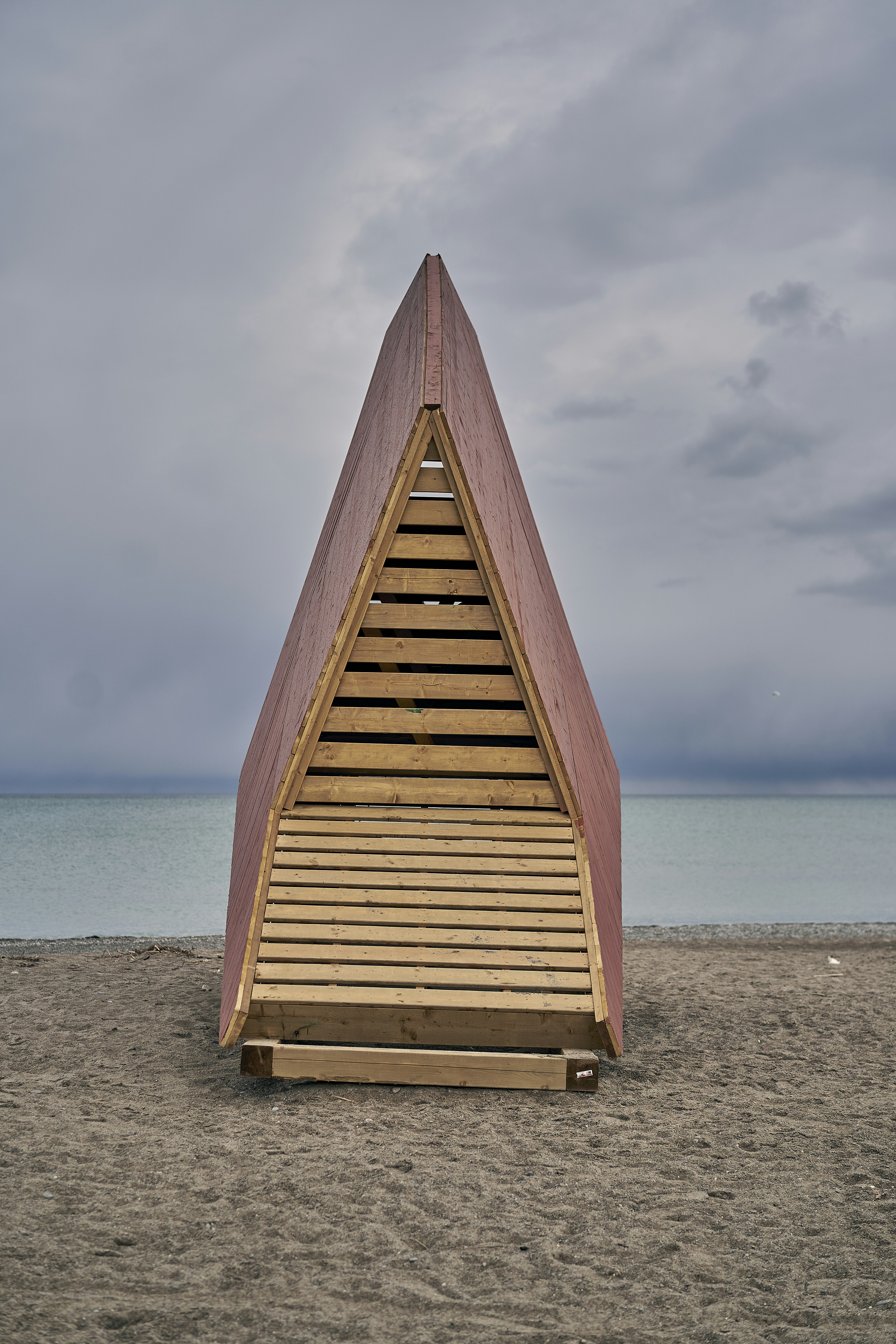 Crimson A-Frame Sentinel on a Quiet Seashore