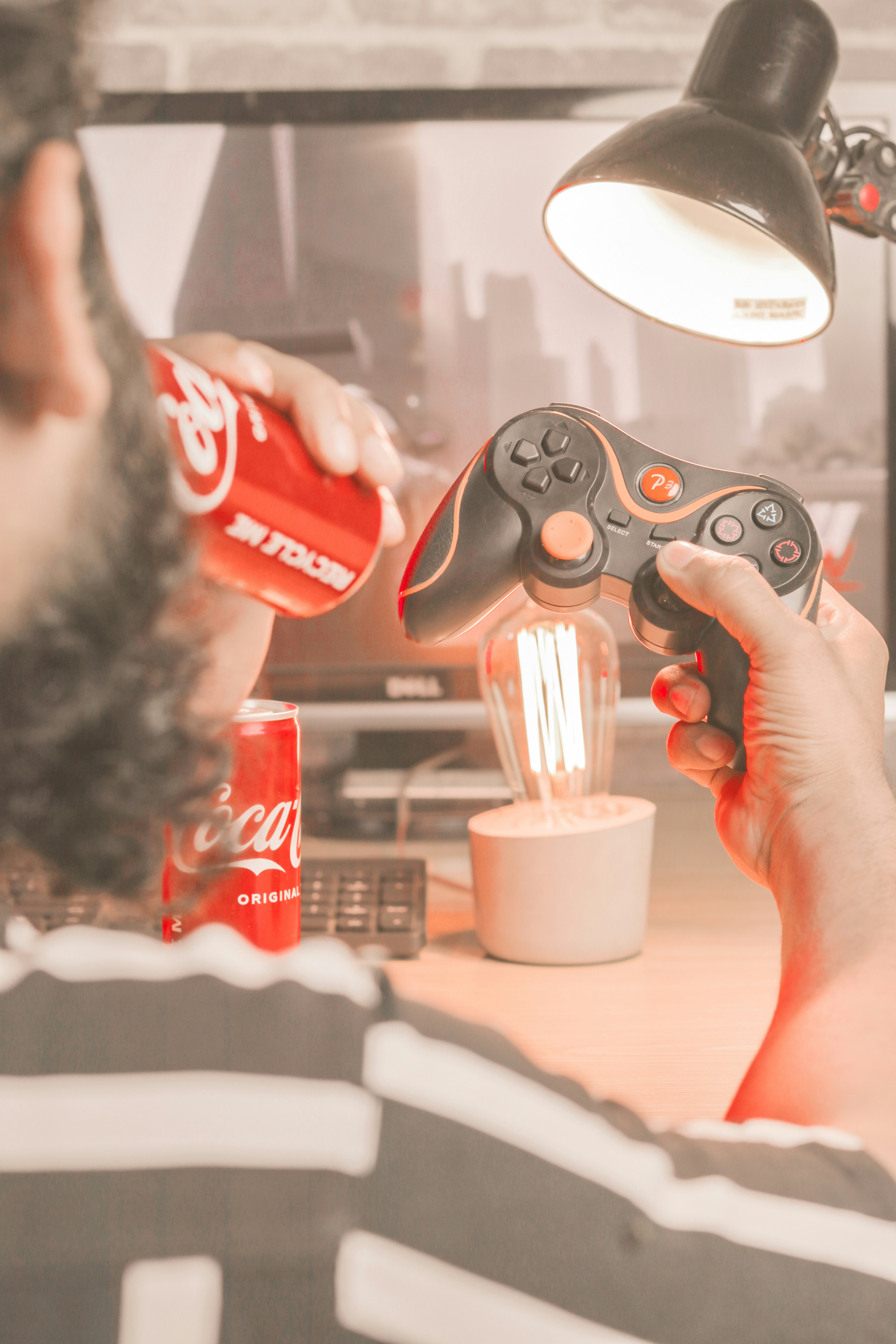 Coca-Cola and Controller: A Gamer’s Break Amid a Neon Desk Lamp