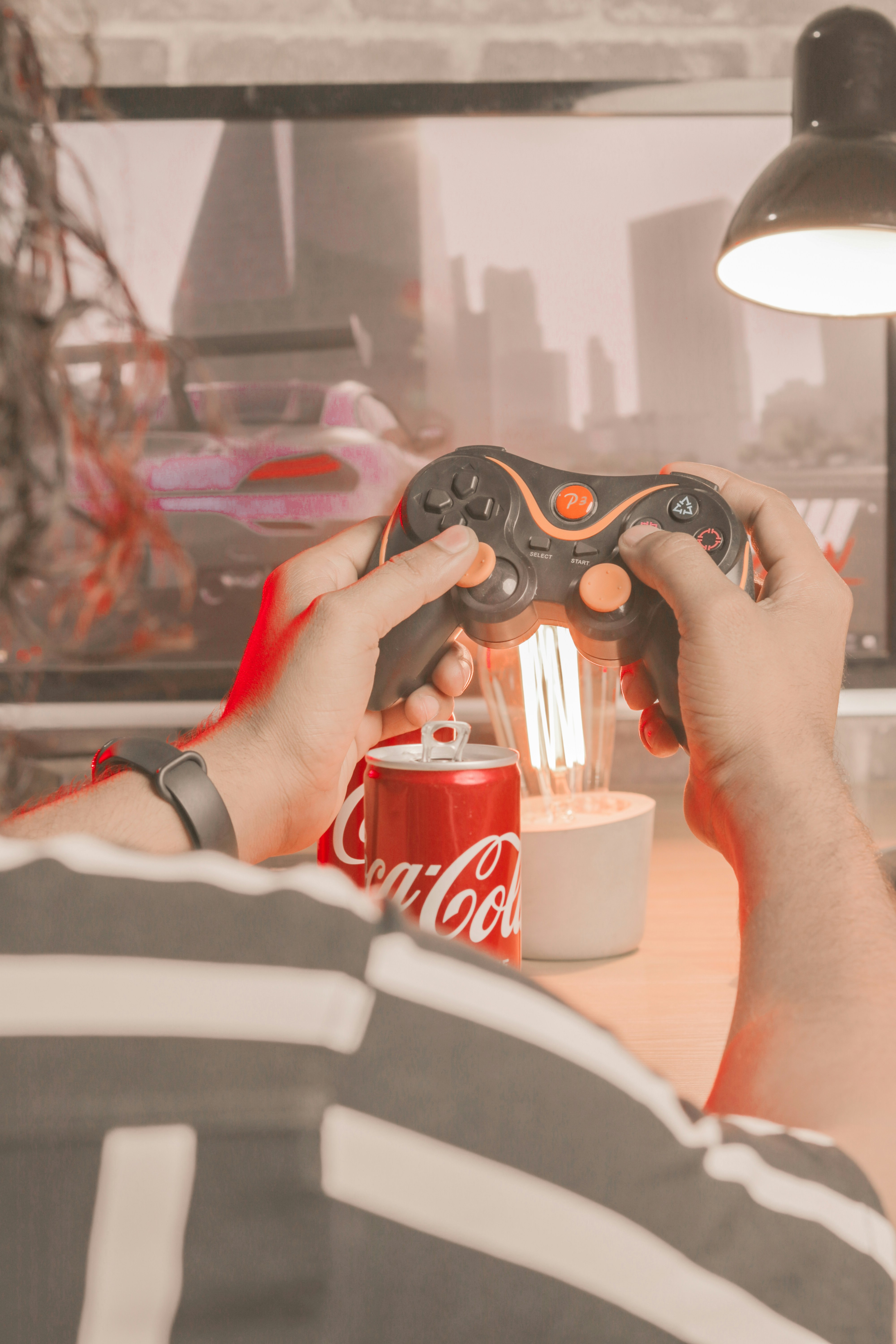 Center Stage: Hands Grip a Game Controller Amid Coca-Cola Glow