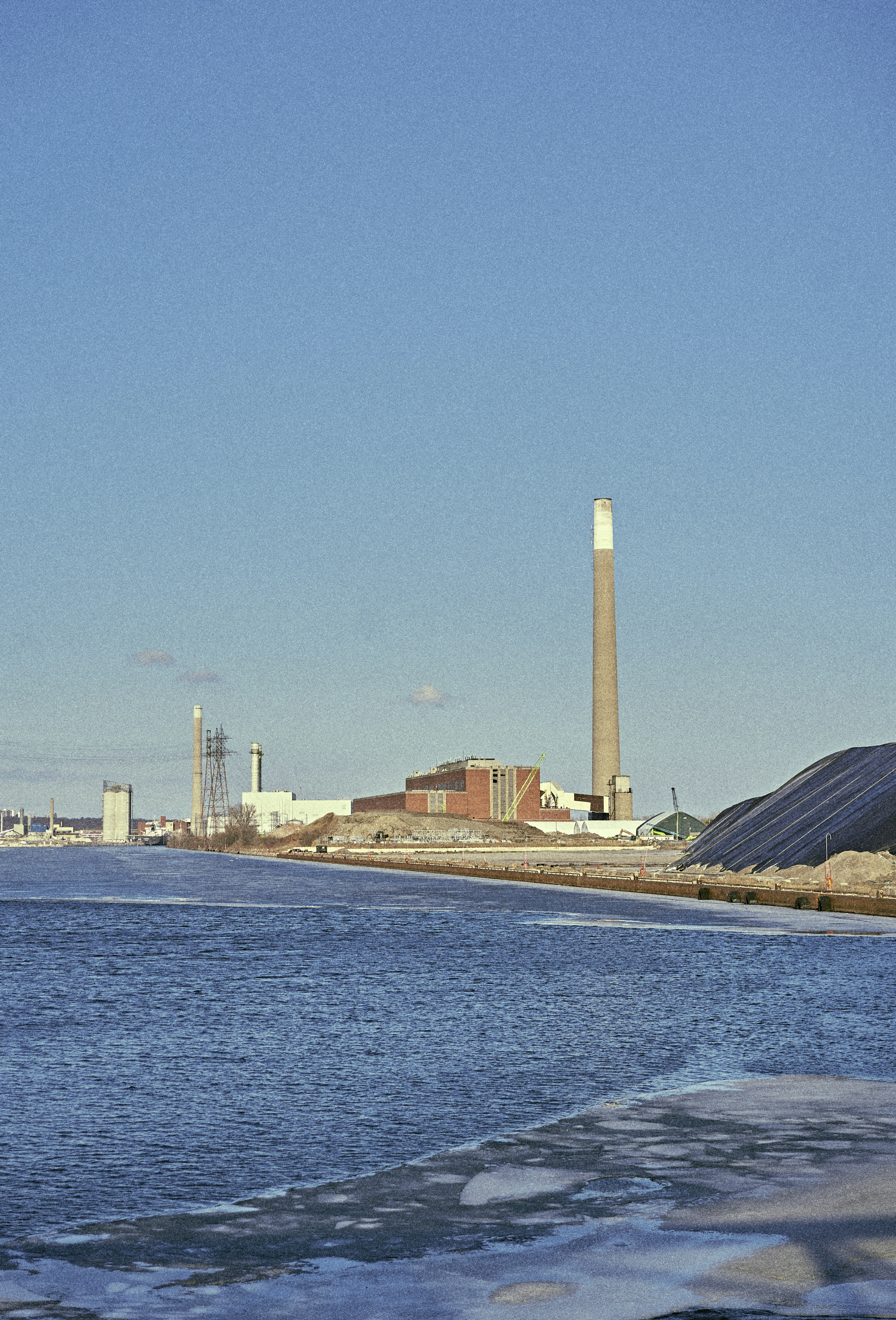 a body of water with a power plant in the background