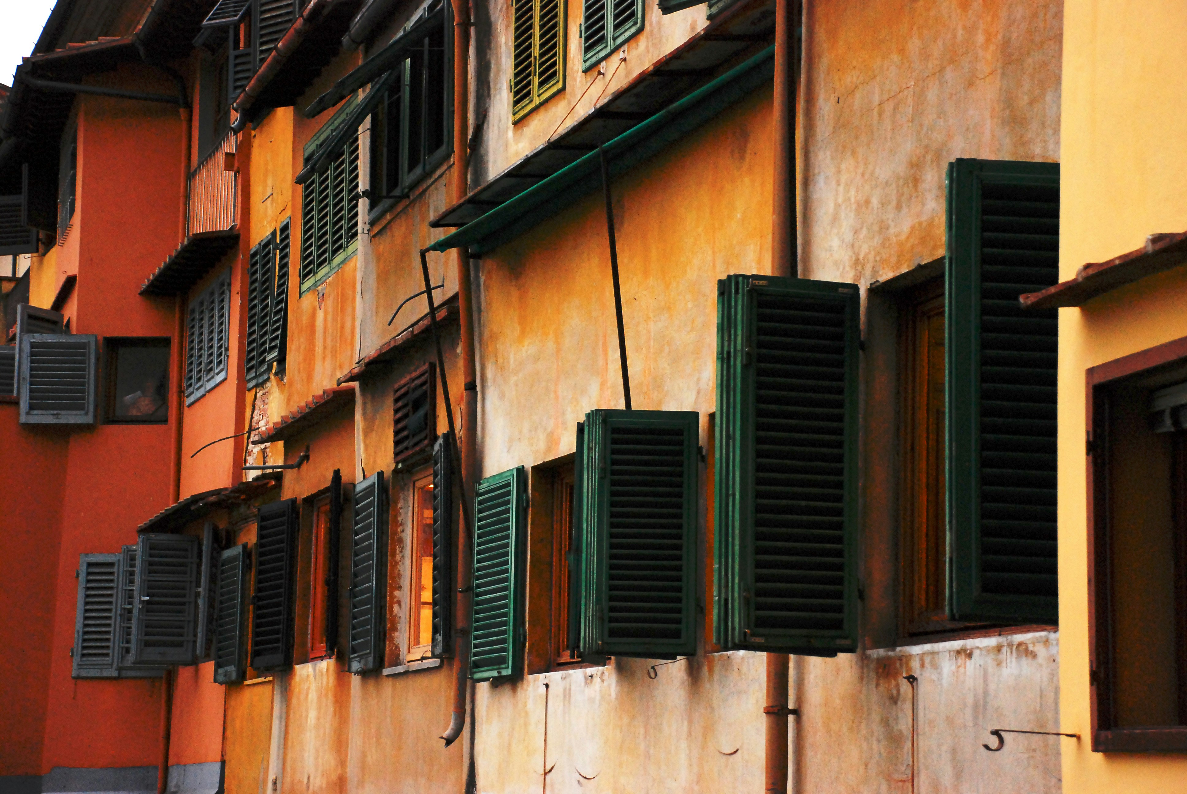 A row of windows with green shutters on a building photo – Free Window ...