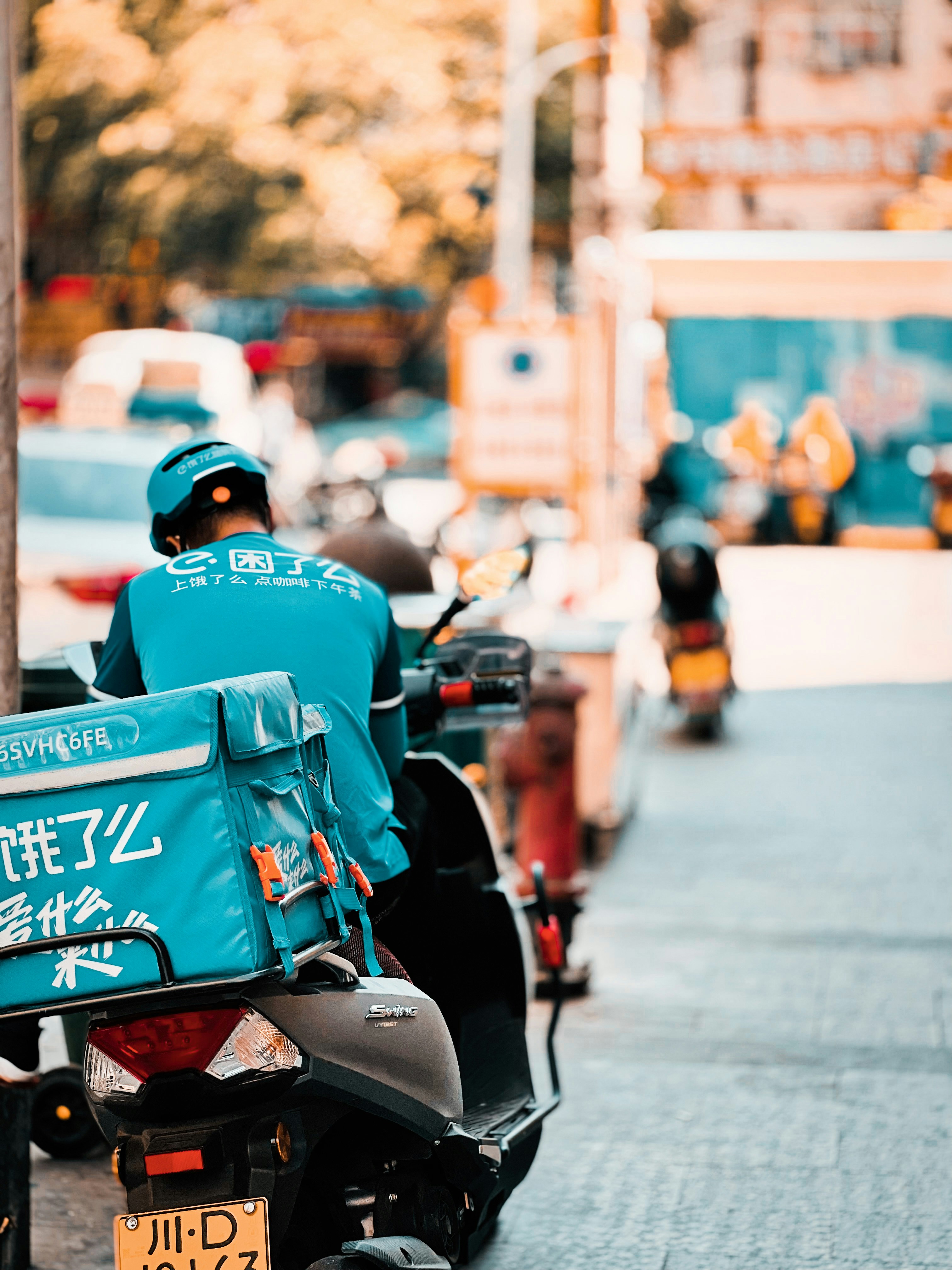 A man riding a scooter down a city street photo – Free 攀枝花市 Image on ...