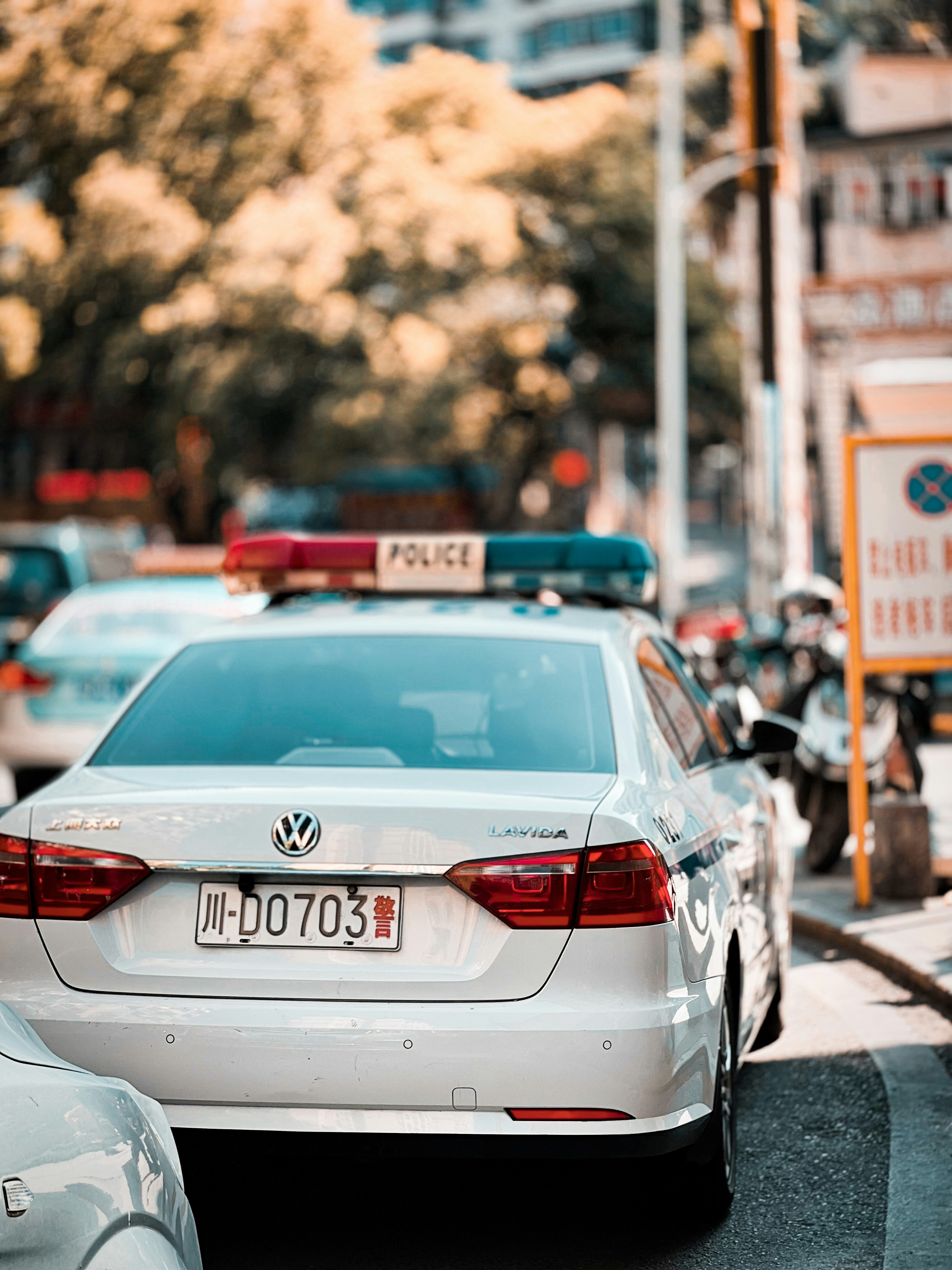 City Siren: A White Police Sedan Anchors a Bustling Street