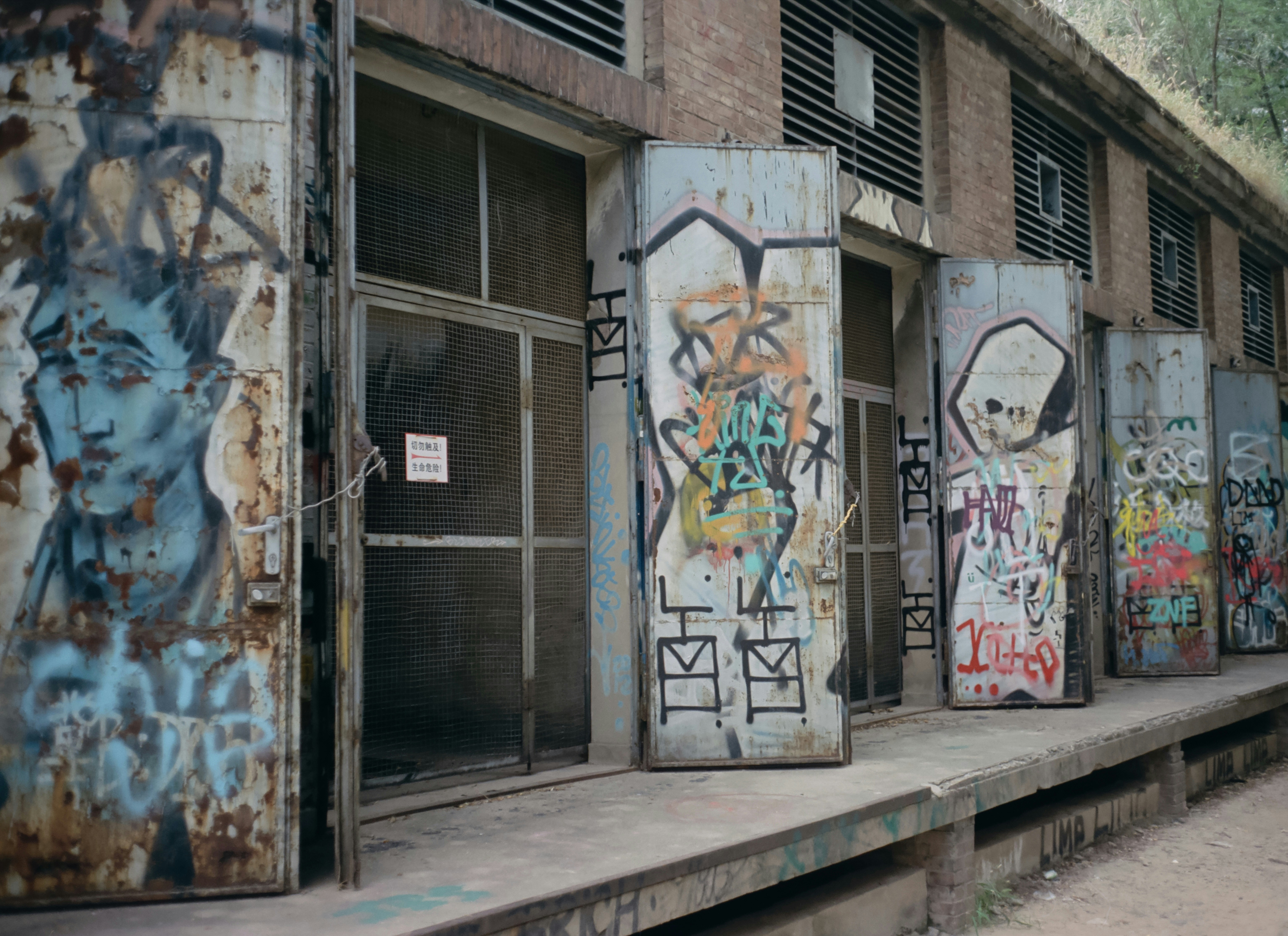 A bunch of graffiti on the side of a building photo – Free Grey Image ...