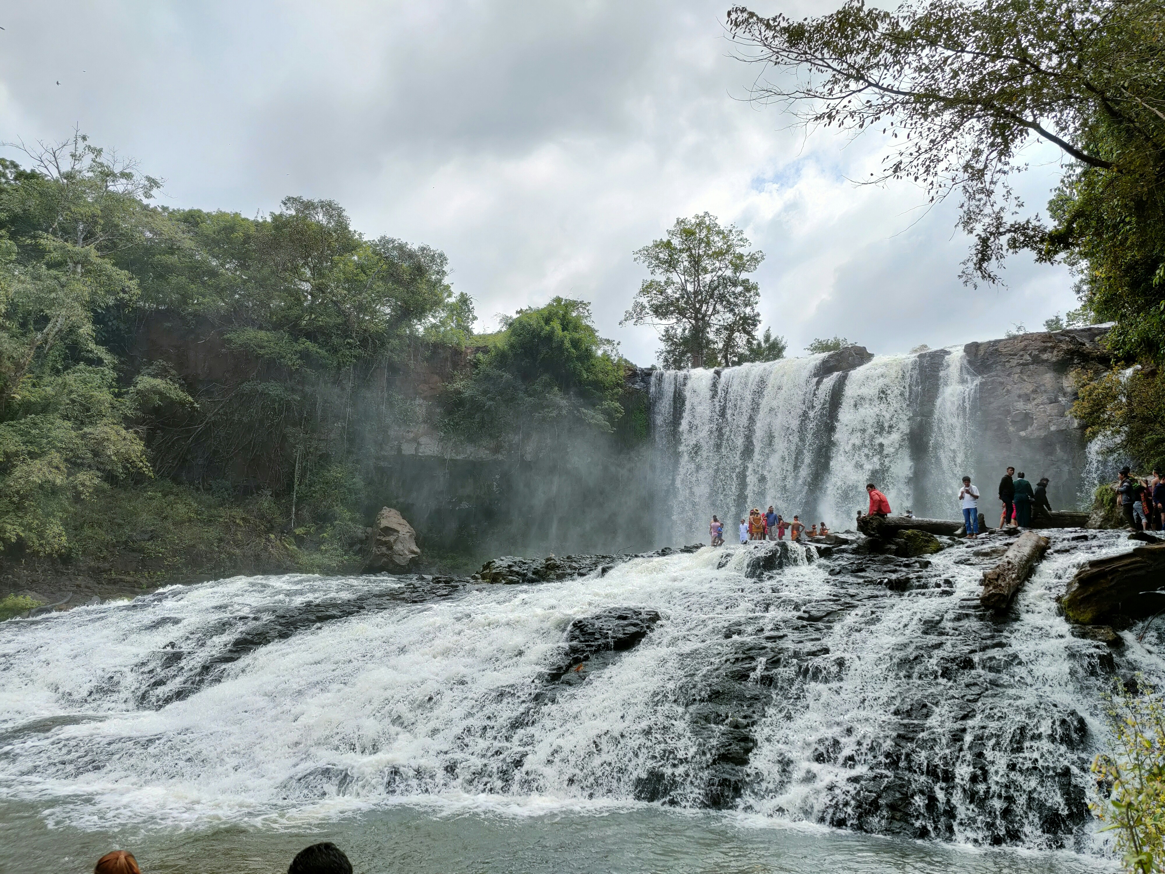 Un groupe de personnes debout devant une cascade photo – Photo Gris ...
