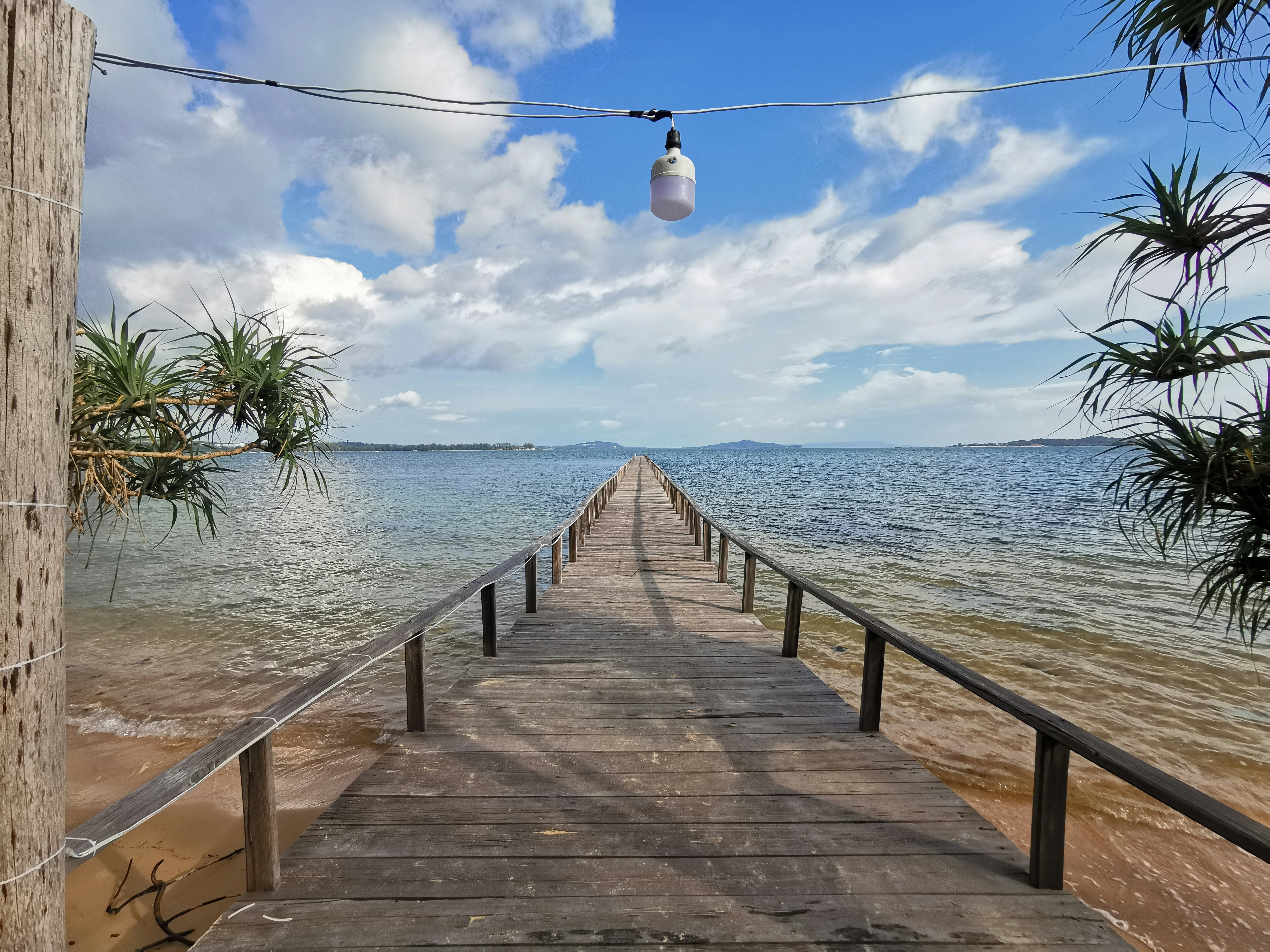 Un quai en bois avec une lumière suspendue au-dessus photo – Photo Bleu ...