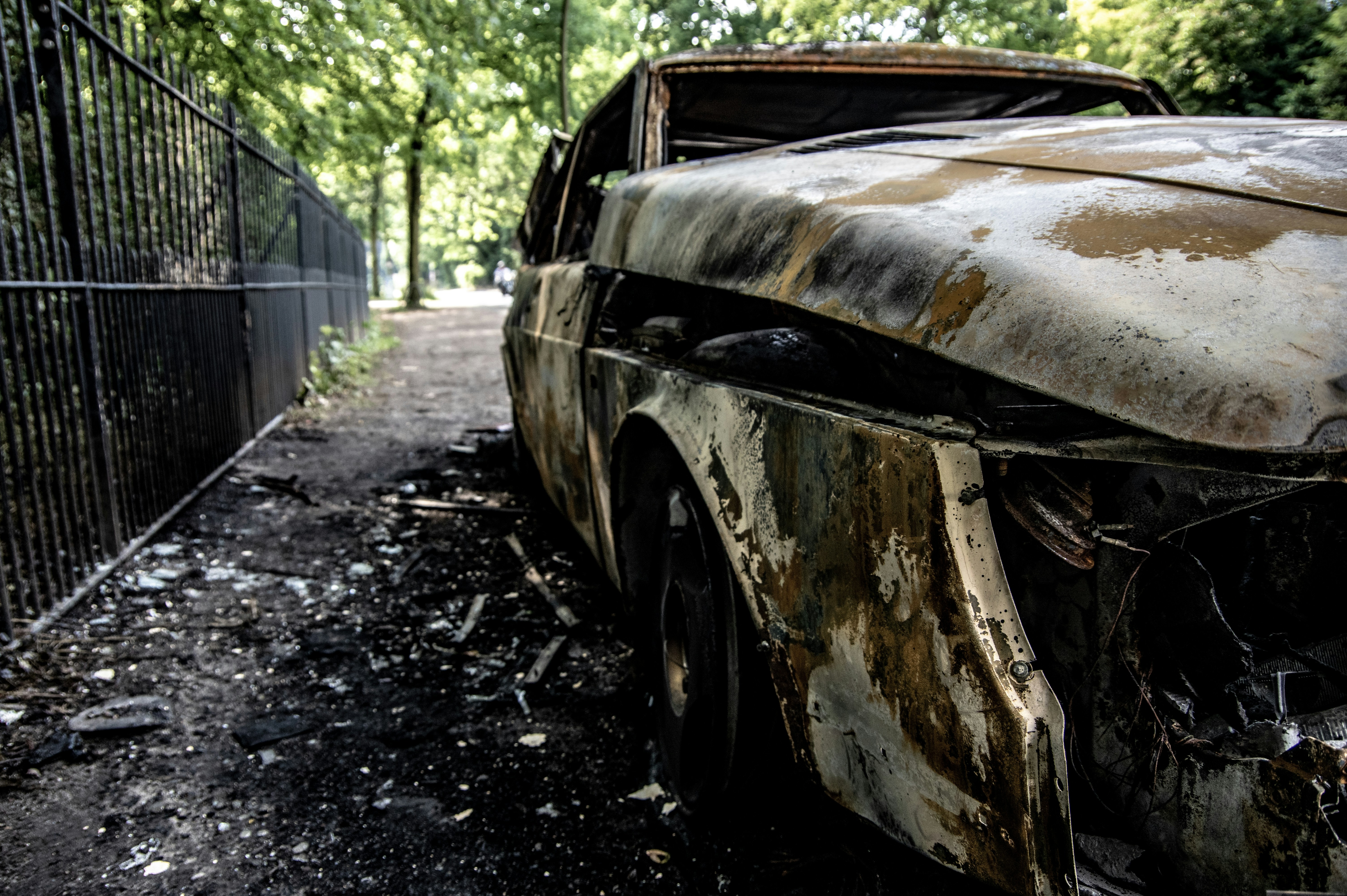 A burnt out car sitting on the side of a road photo – Free Car Image on ...