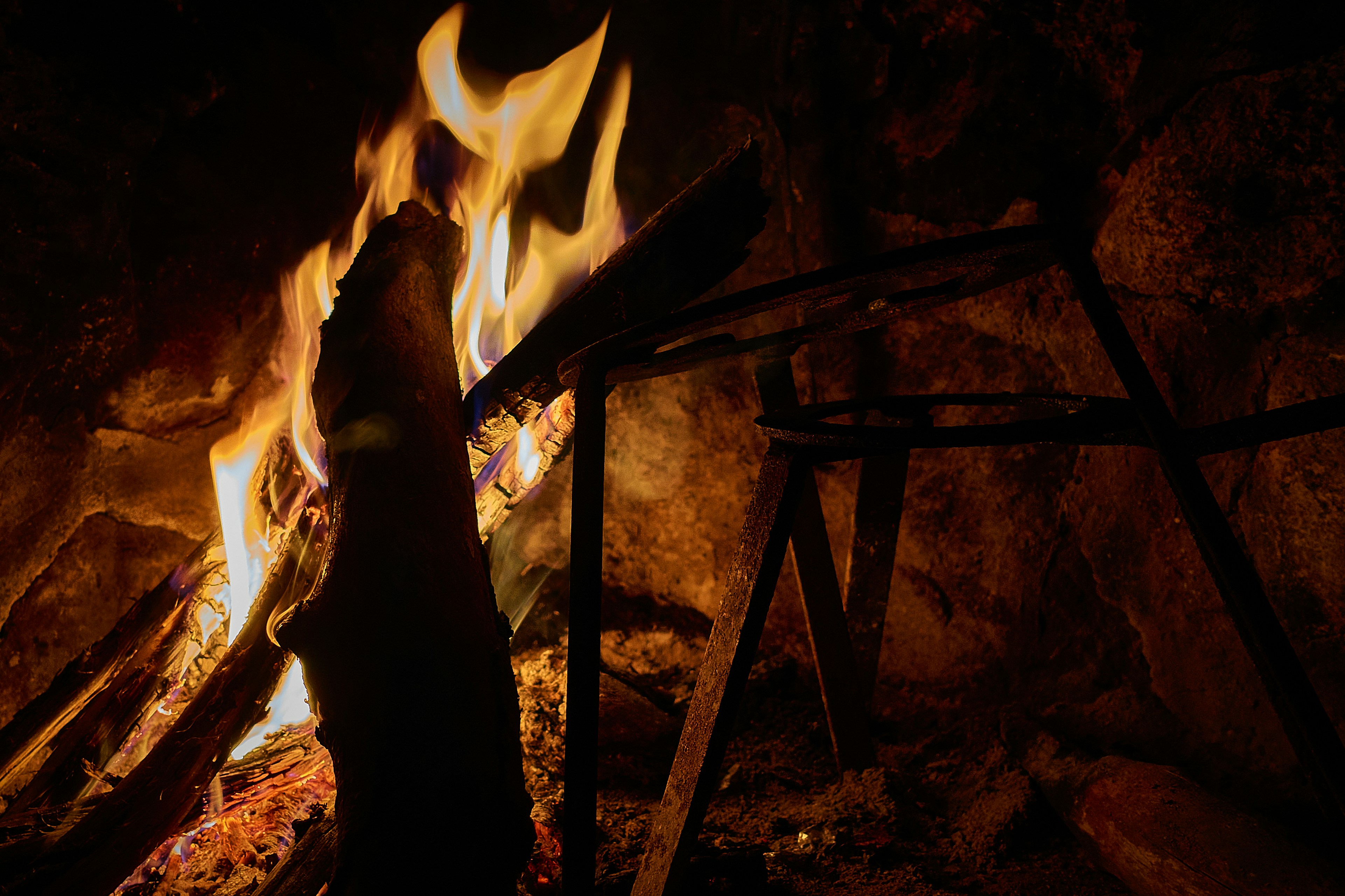 A fire burning inside of a stone fireplace photo – Free Luzenac ...