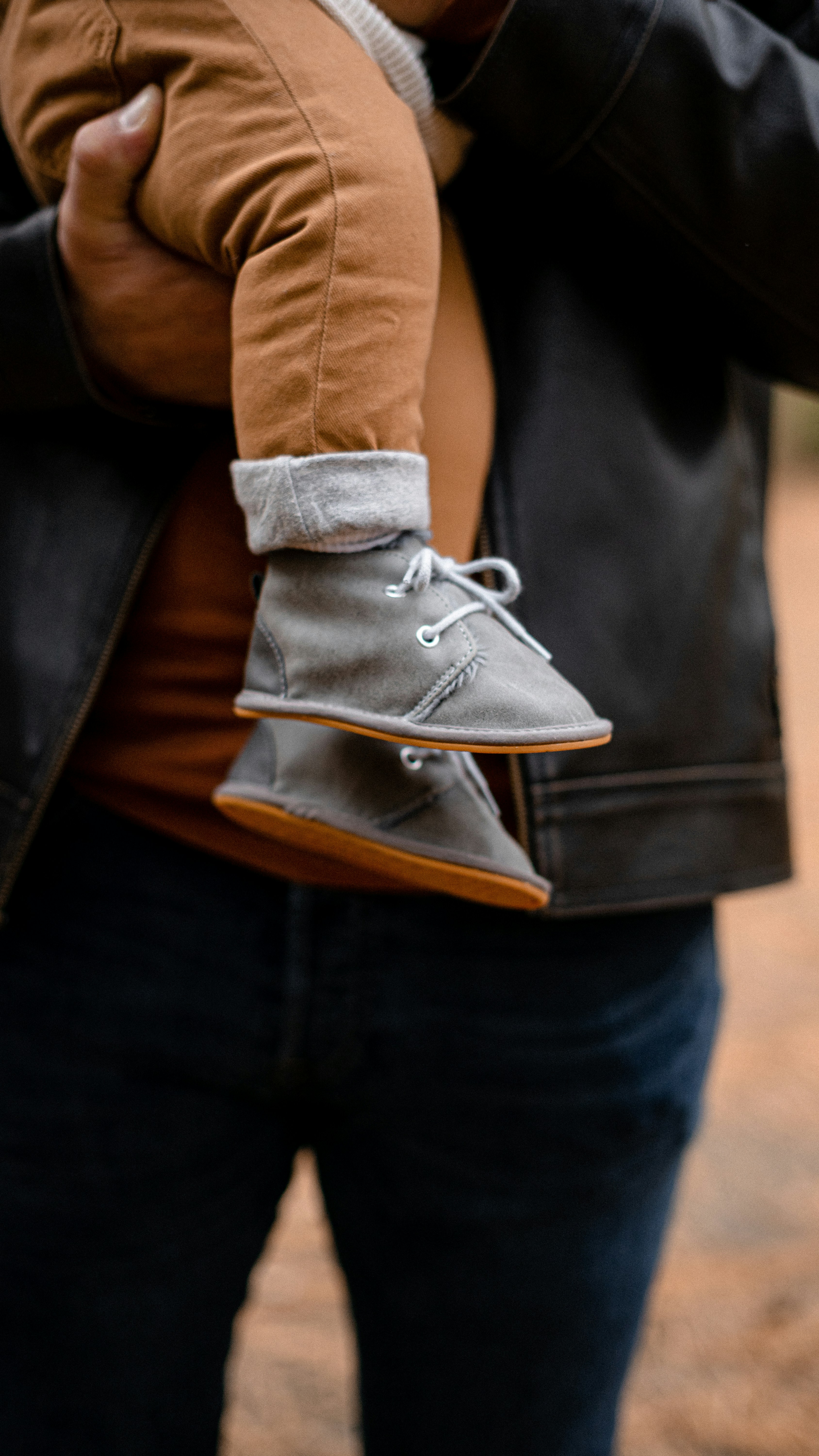 Tiny Gray Booties Dangling in a Gentle Lift