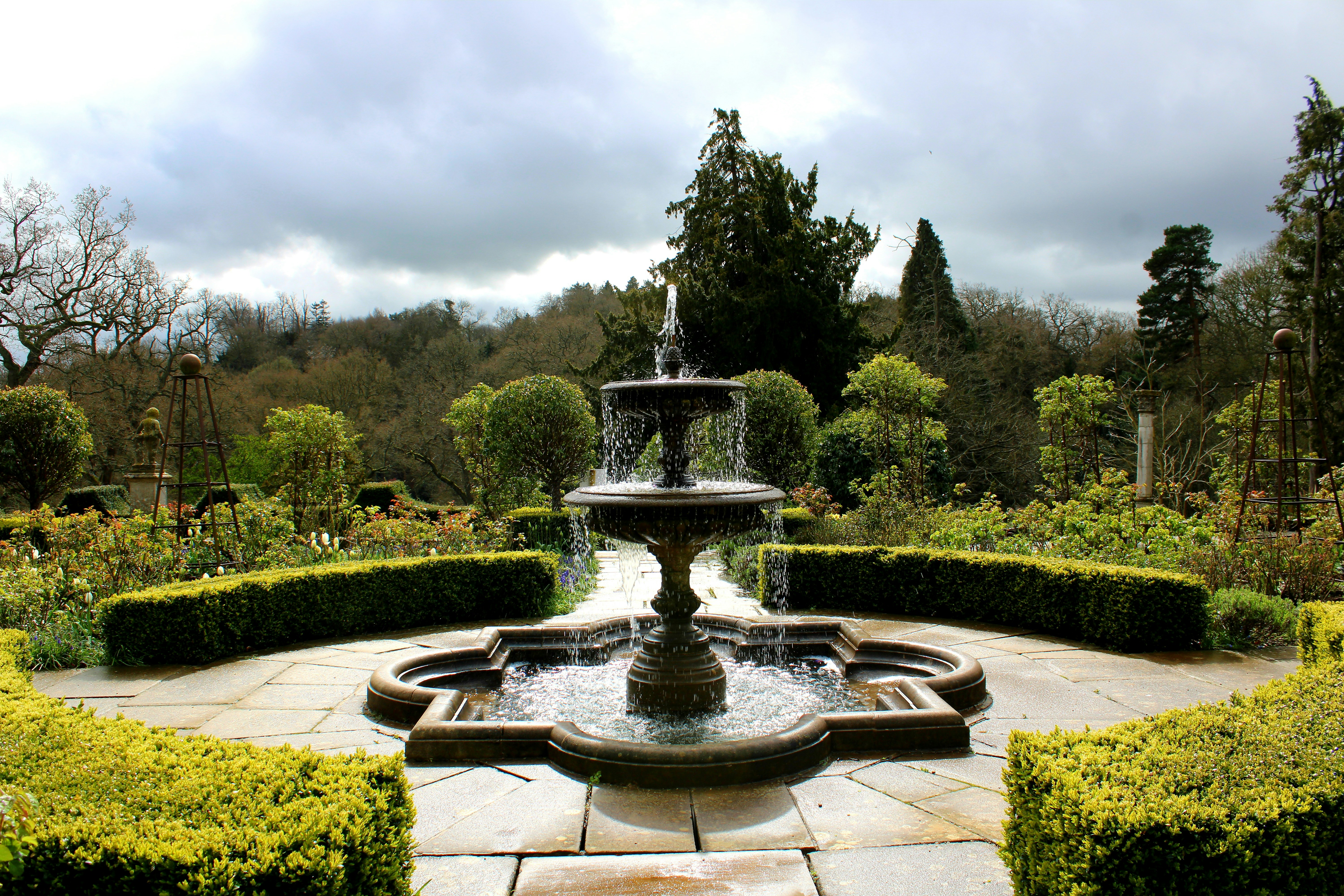 A water fountain surrounded by hedges and trees photo – Free Water ...