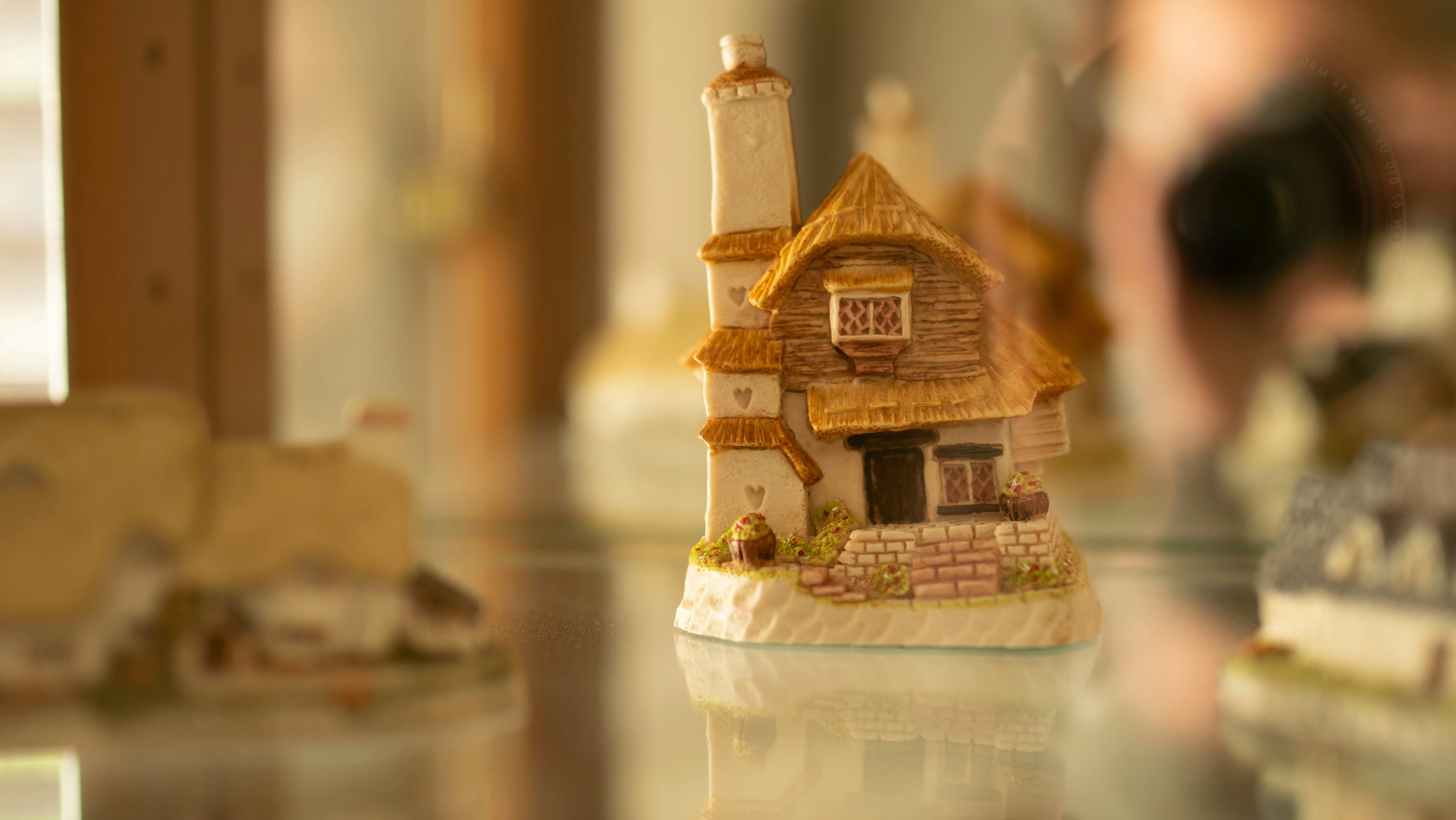 Intricately designed miniature cottage showcasing fine craftsmanship and attention to detail. The scene captures the essence of a charming, handcrafted home.