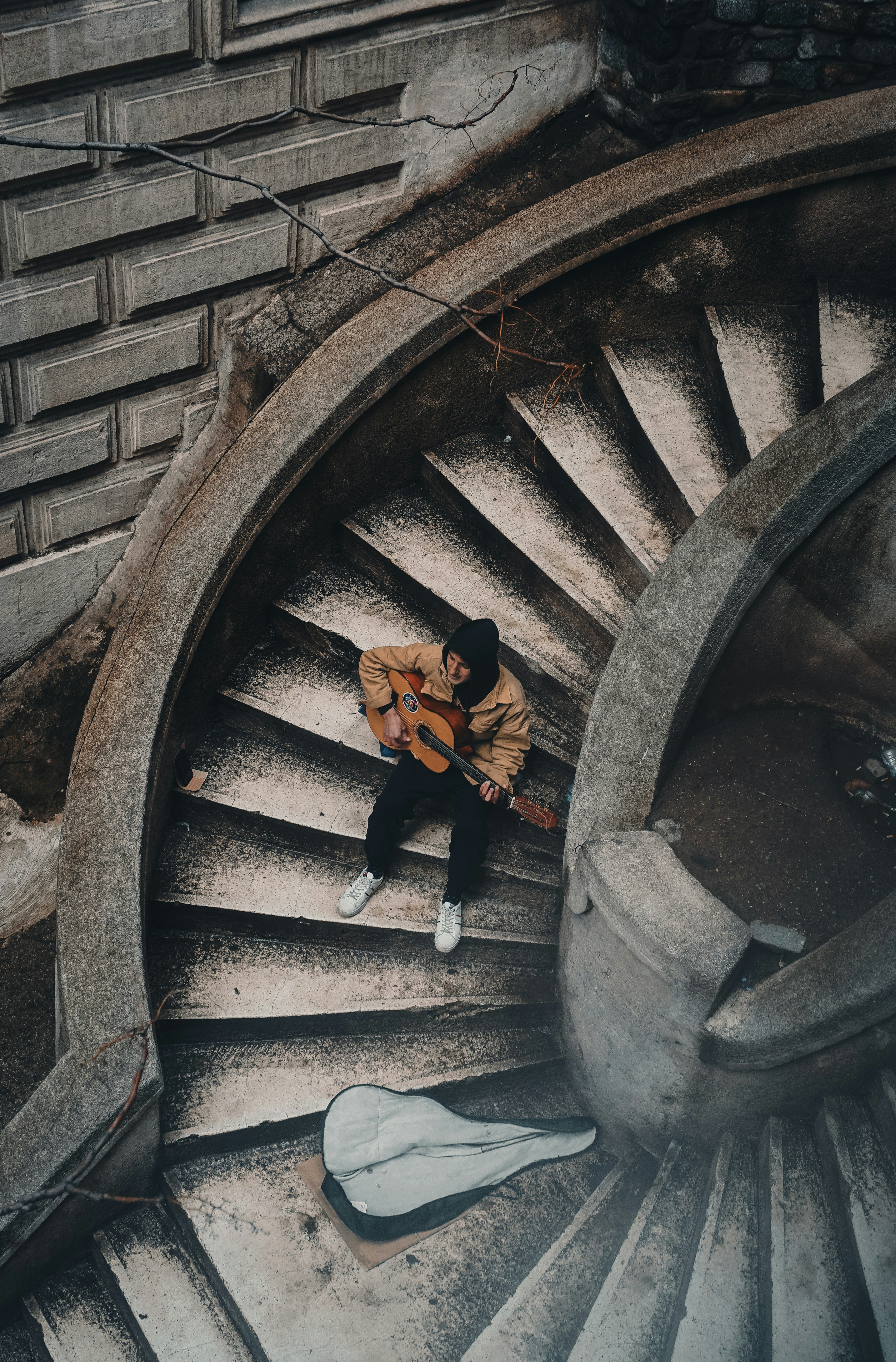 Serenade on the Stone Spiral: A lone guitarist among weathered steps
