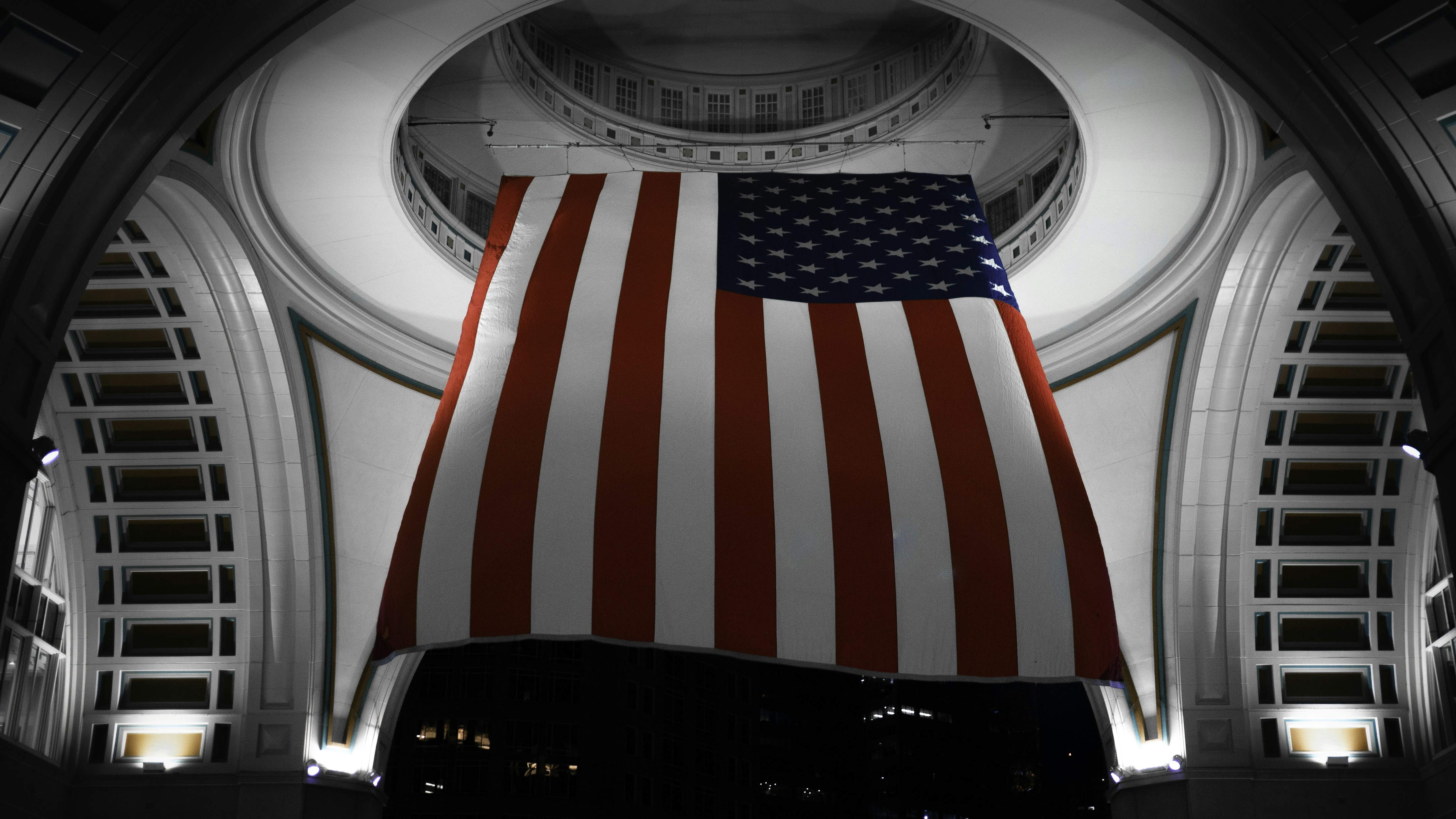 A large american flag hanging from the ceiling of a building photo ...