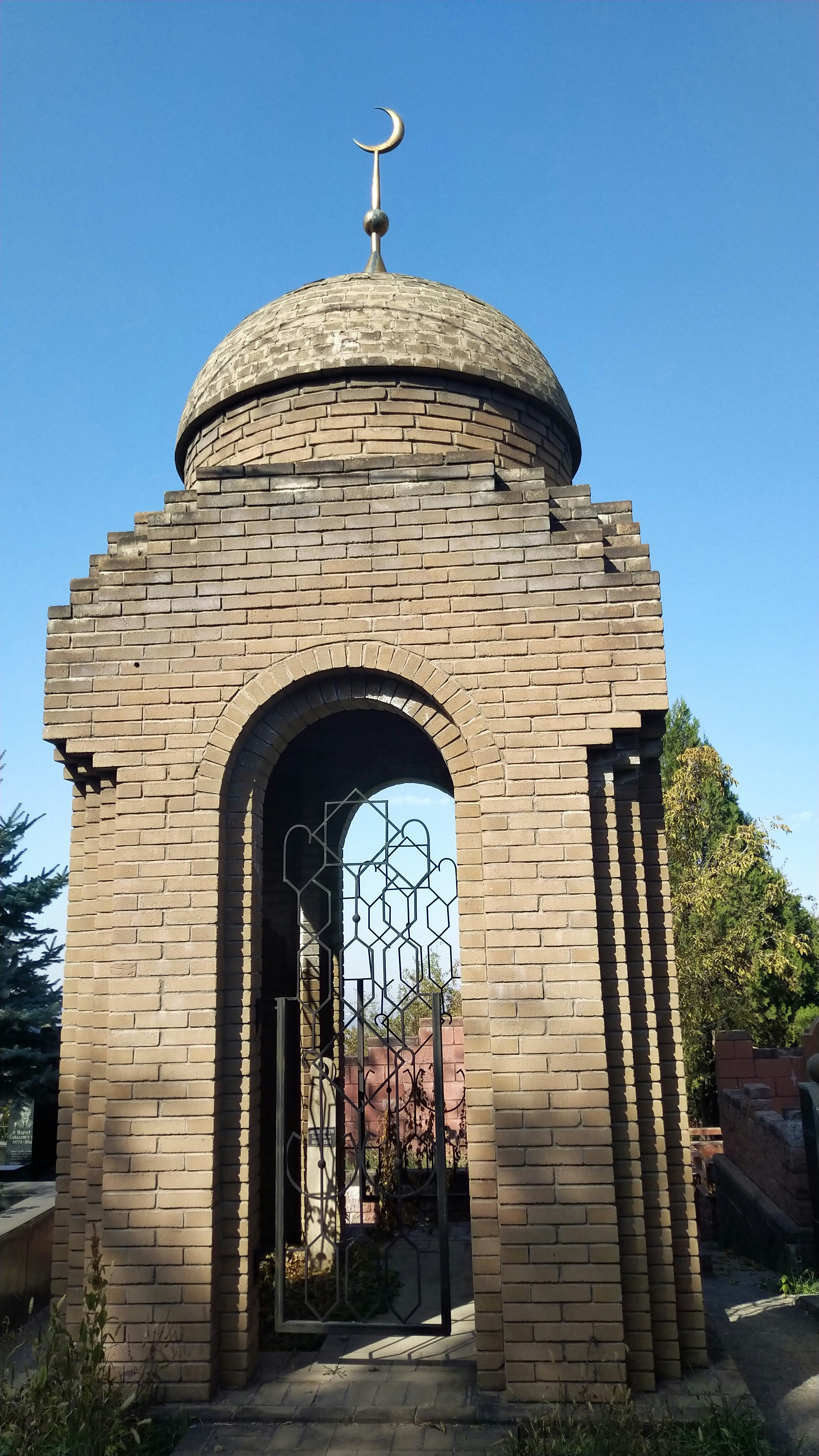 Crescent Guard: A Sunlit Brick Archway with Iron Gate