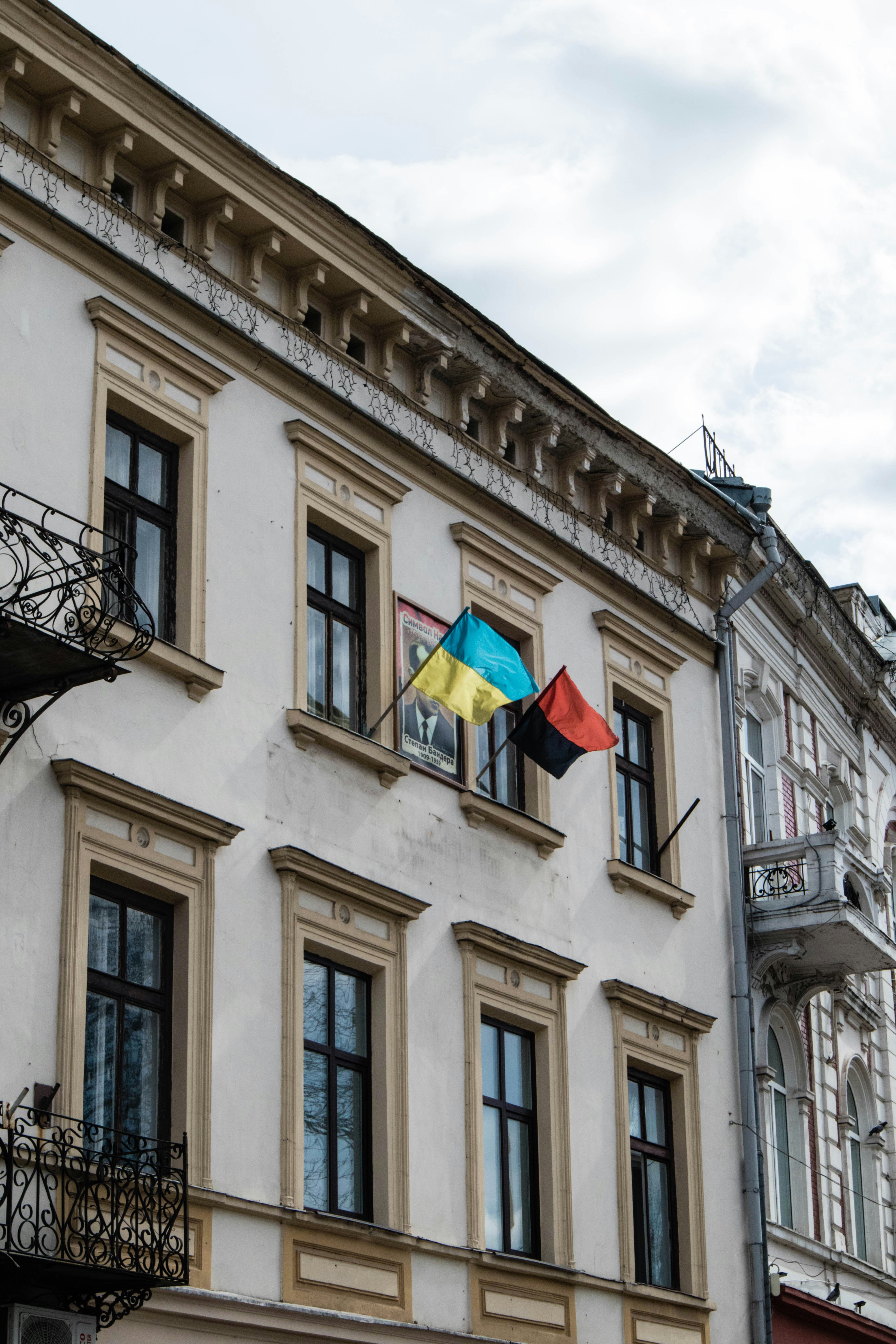 a multicolored kite flying in front of a building