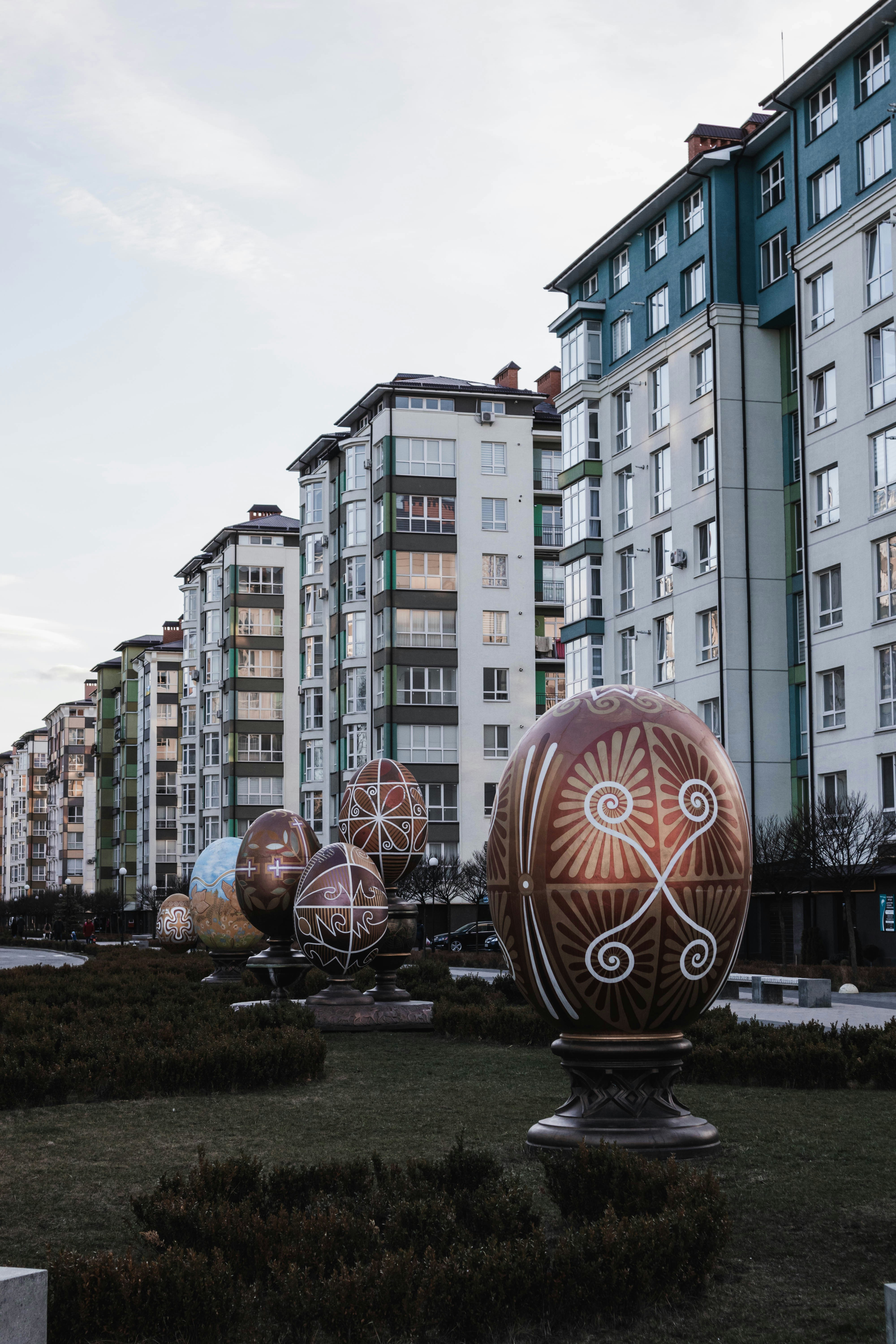 Ornate Egg Sculptures Rise Along a Row of Modern Flats