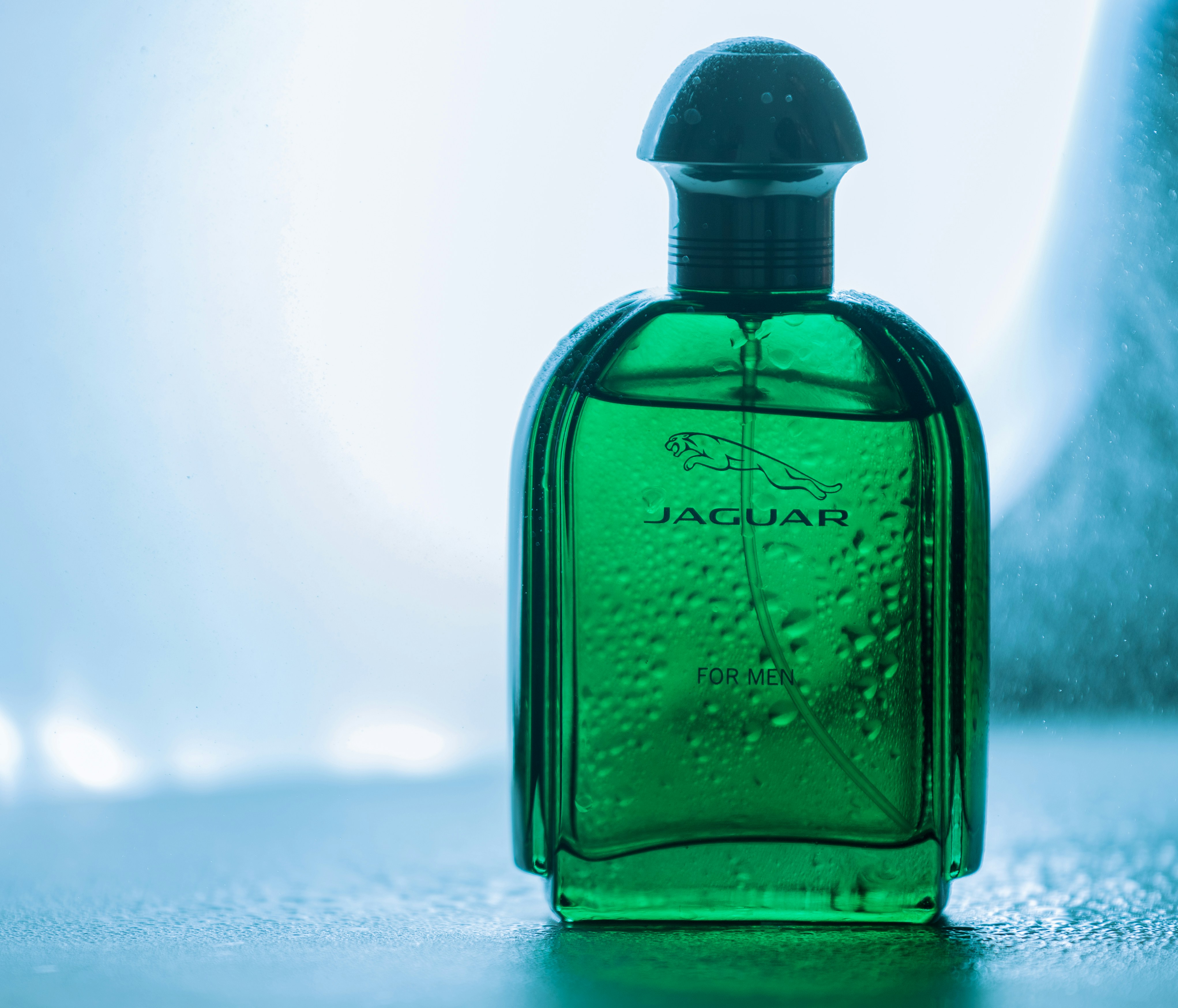 Un flacon de parfum vert posé sur une table photo – Image gratuite de ...