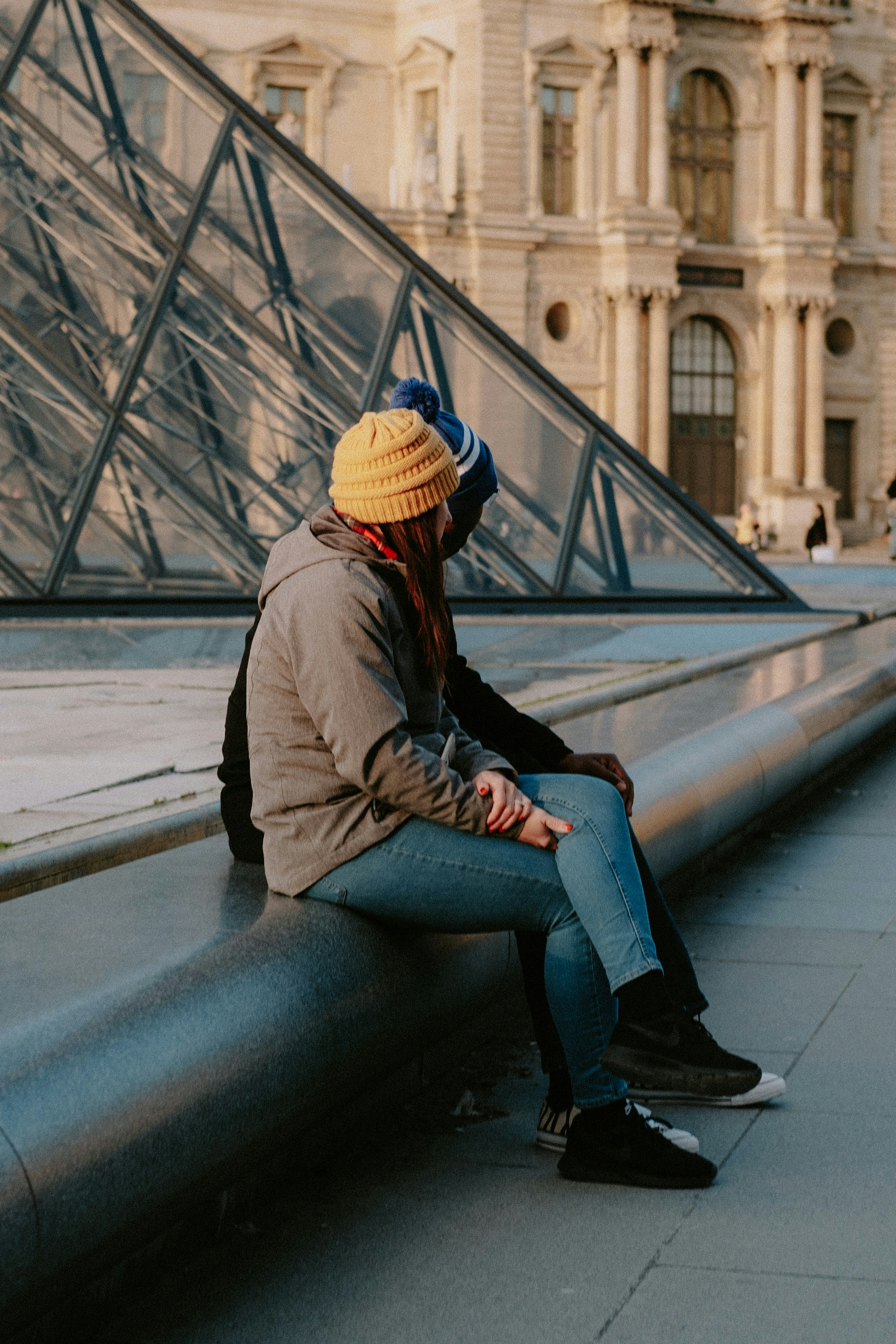 Une personne assise sur un banc devant une pyramide photo – Photo Paris ...