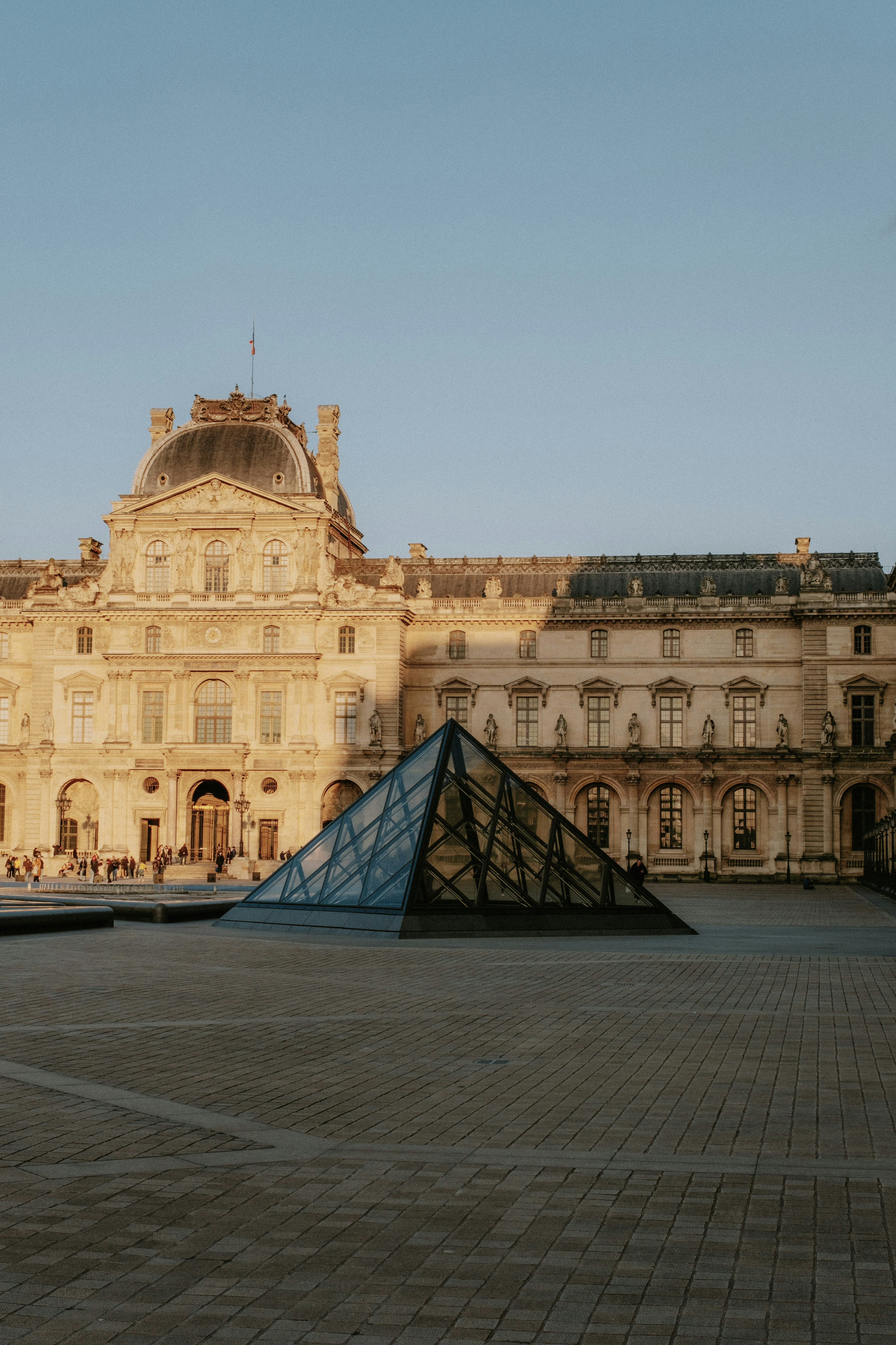 a large building with a pyramid in front of it