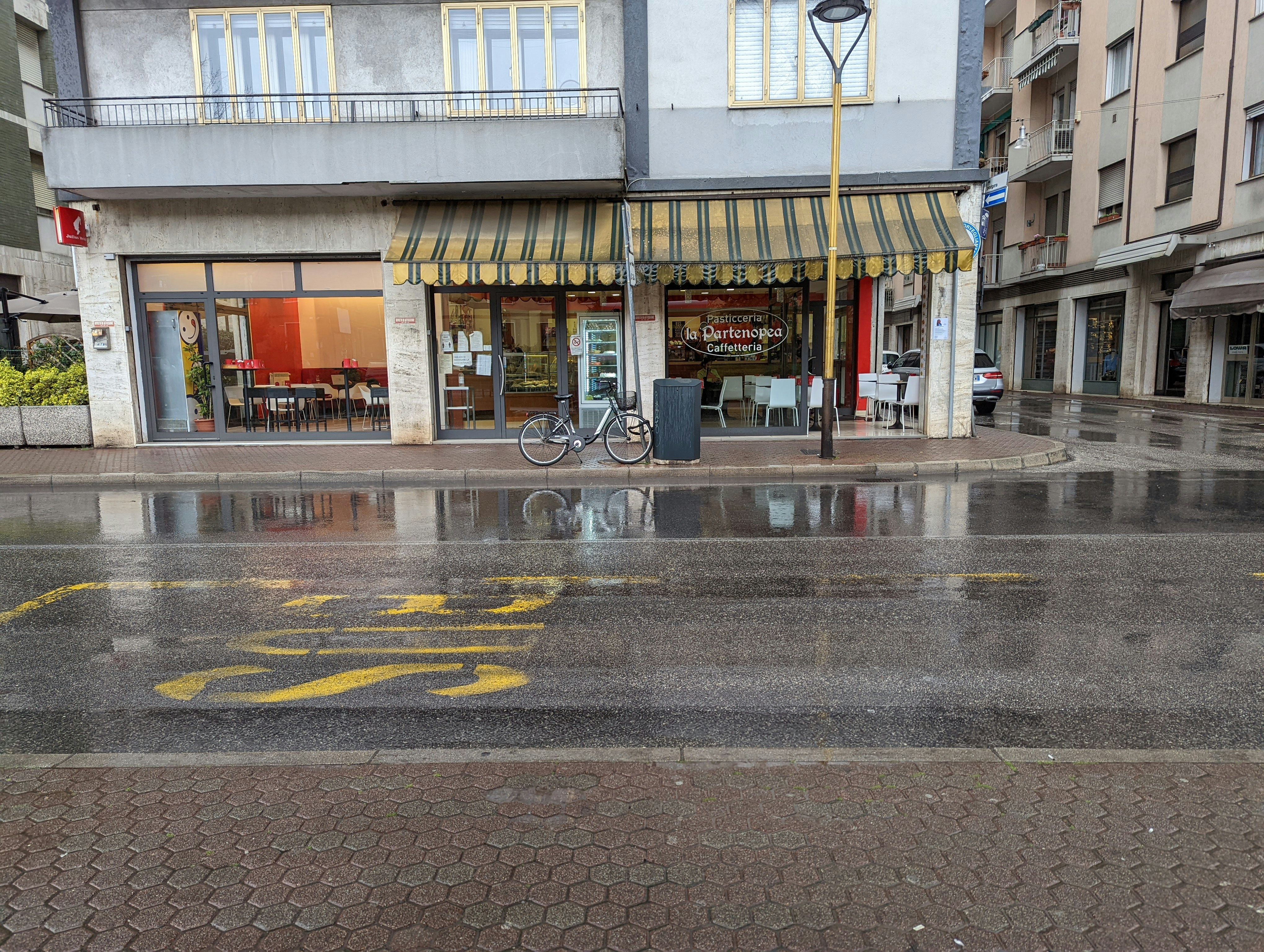 Bicycle by the Striped Awning on a Rain-Washed Street