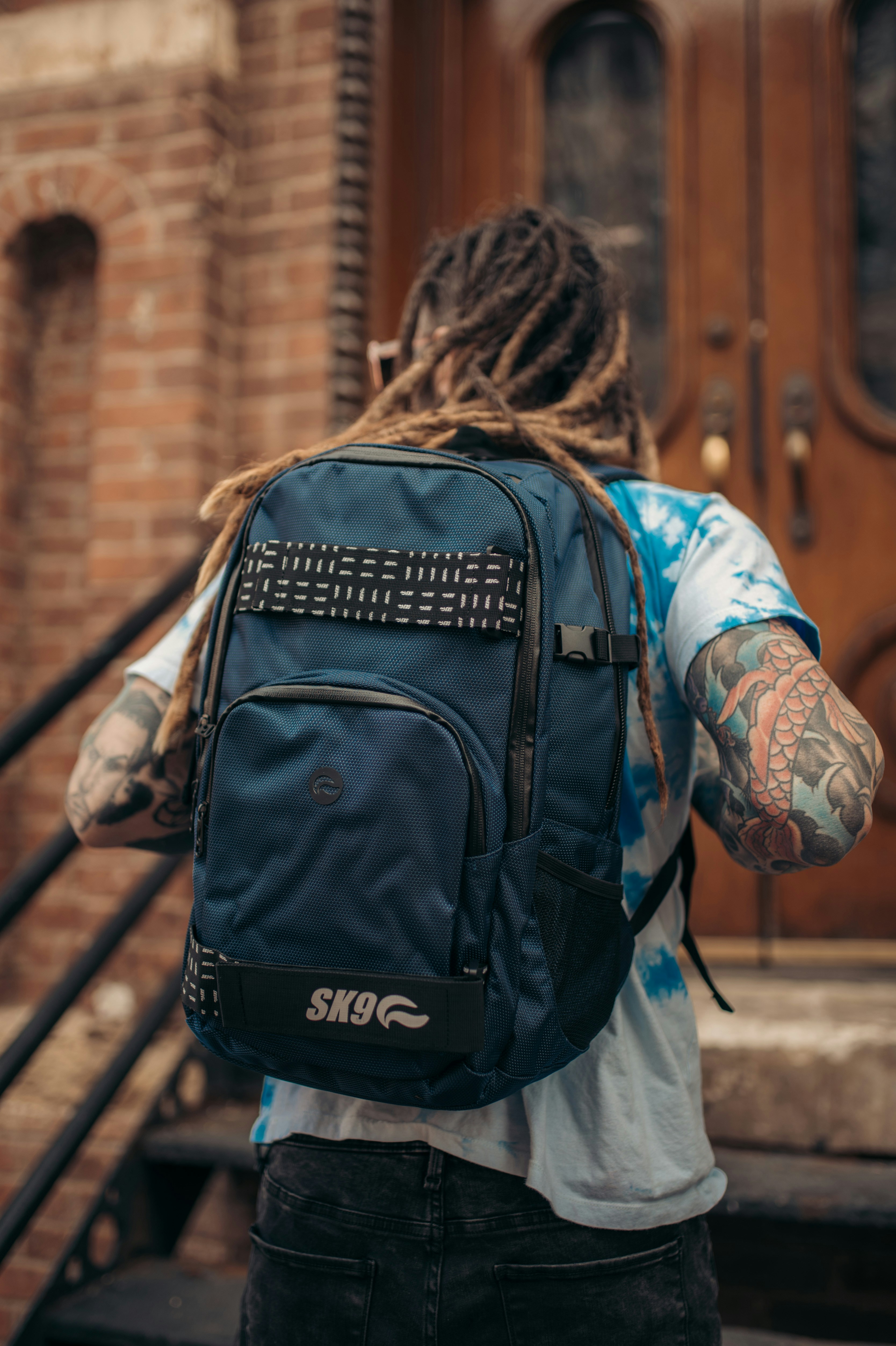 A man with dreadlocks and a blue backpack photo – Free Grey Image on ...