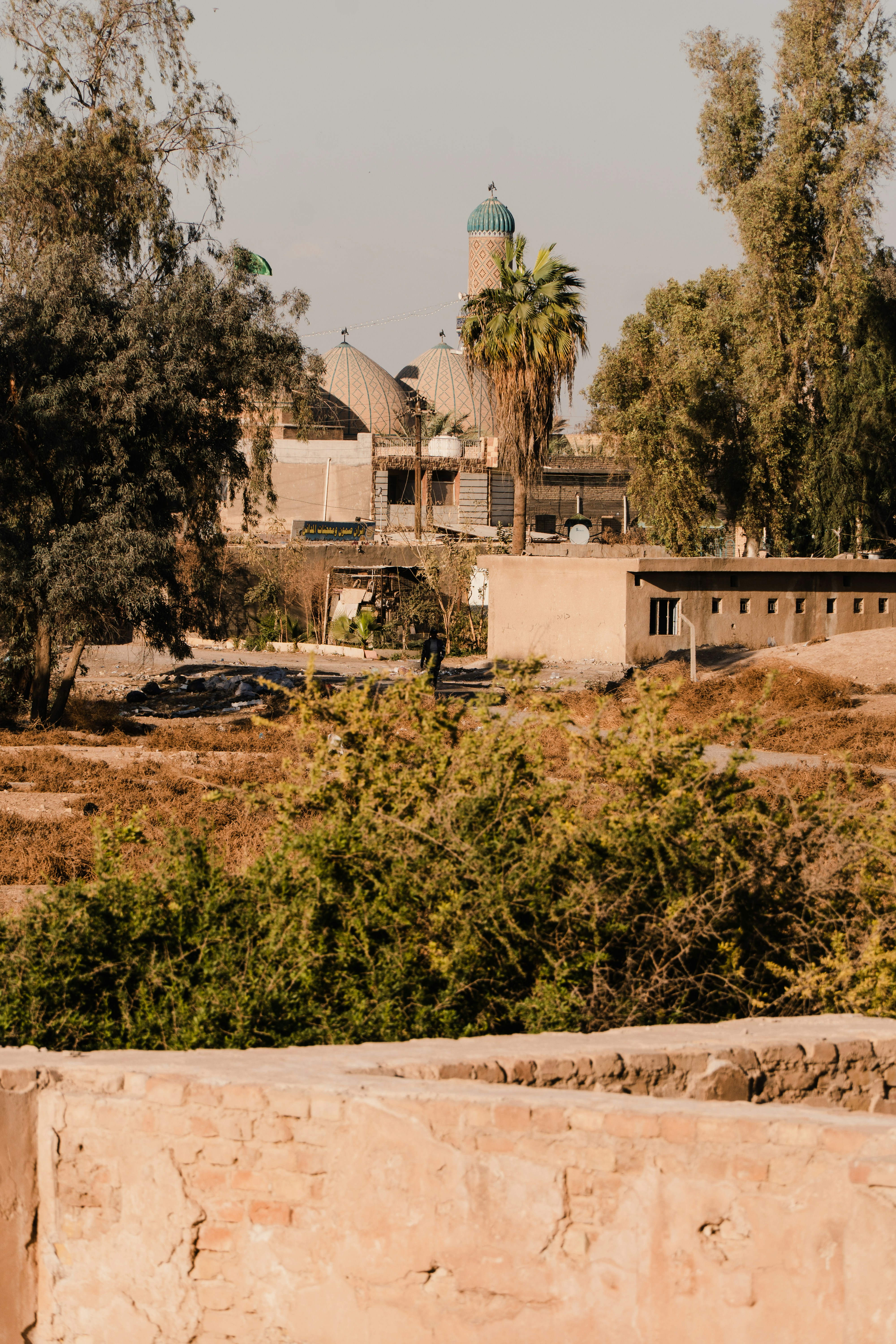 A view of a building with a clock tower in the background photo – Free ...