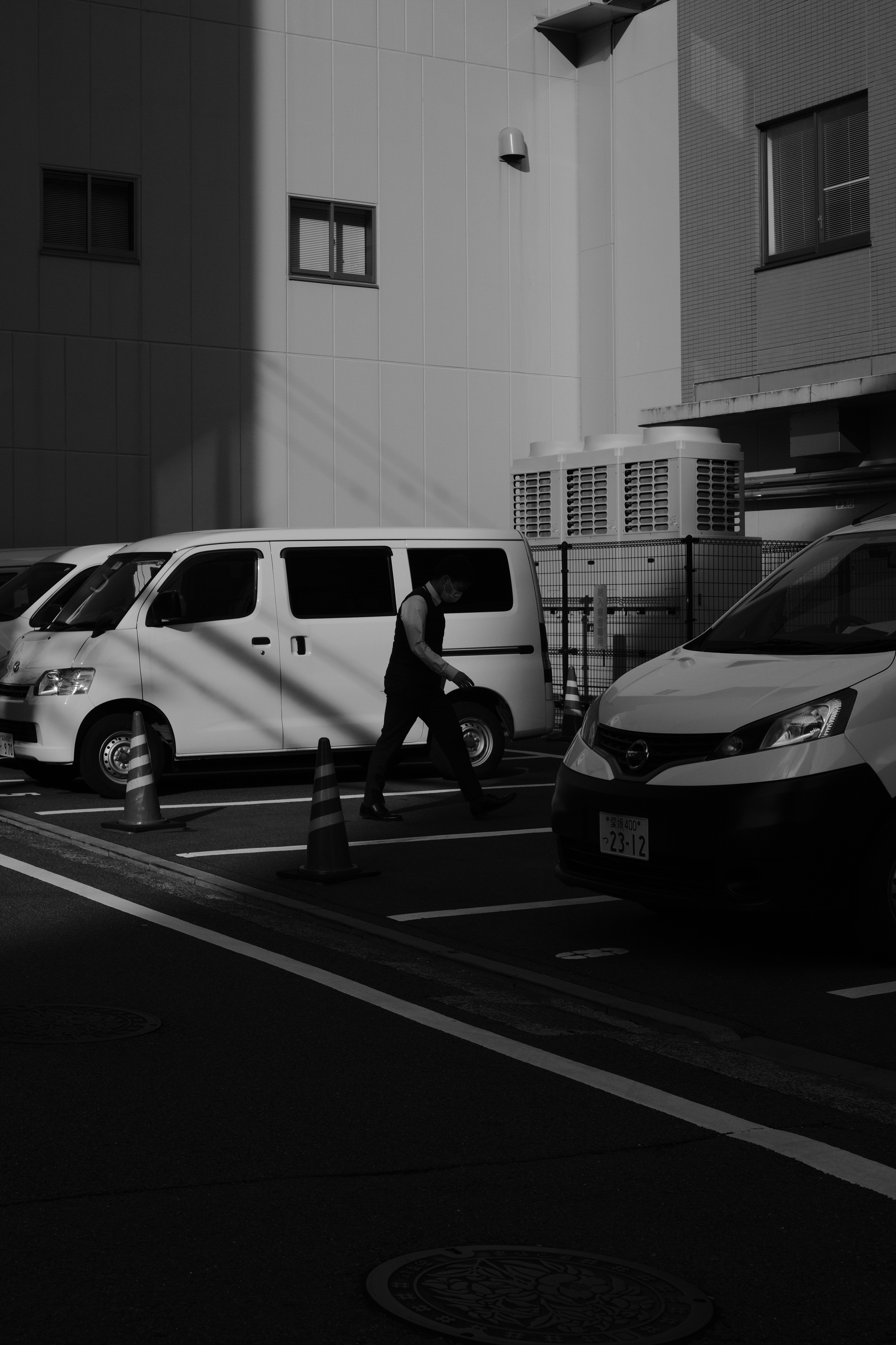 Pedestrian in a Diagonal Shadow: A Quiet Parking Lot Moment