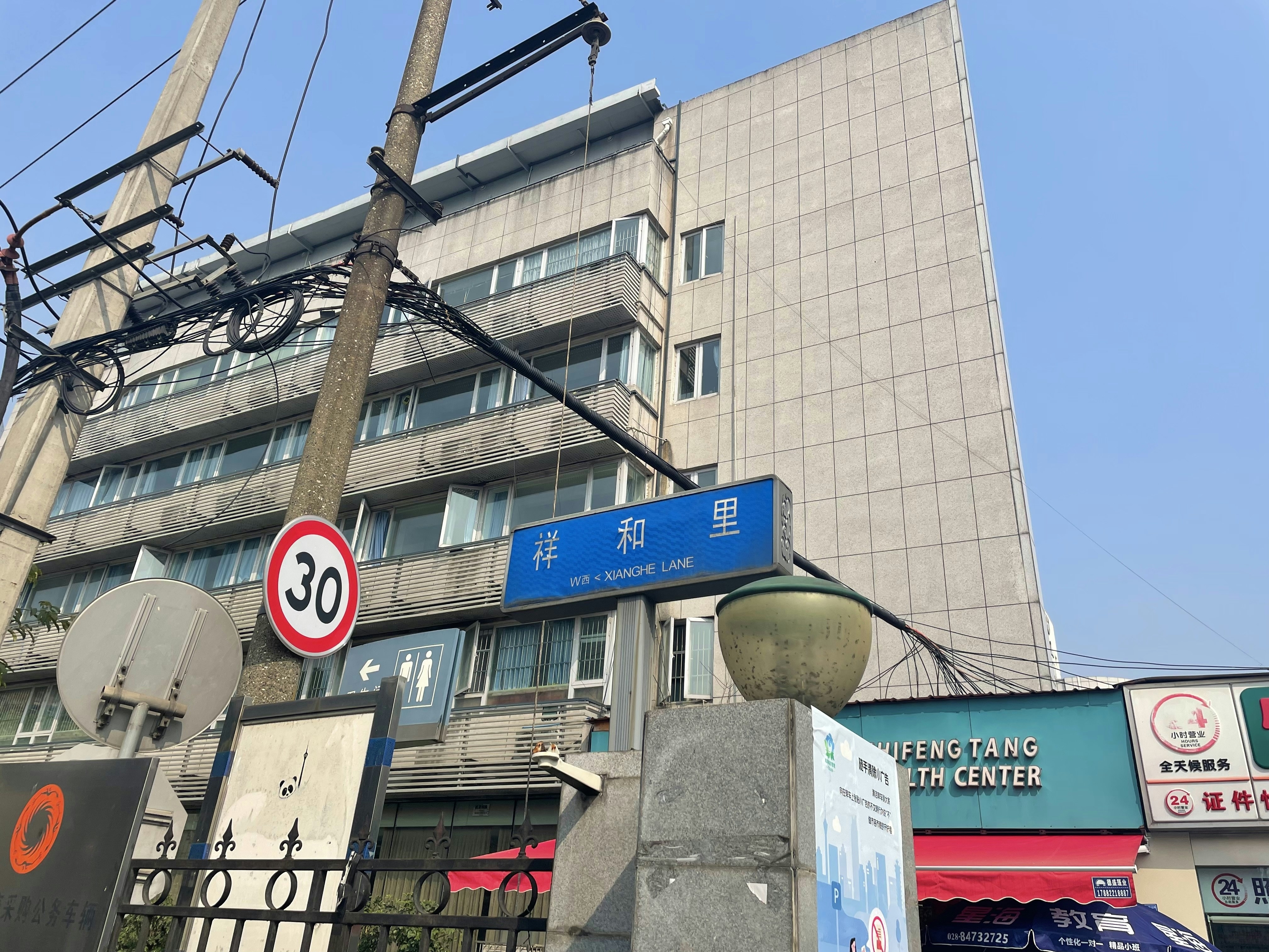 A street sign in front of a tall building photo – Free Sichuan Image on ...